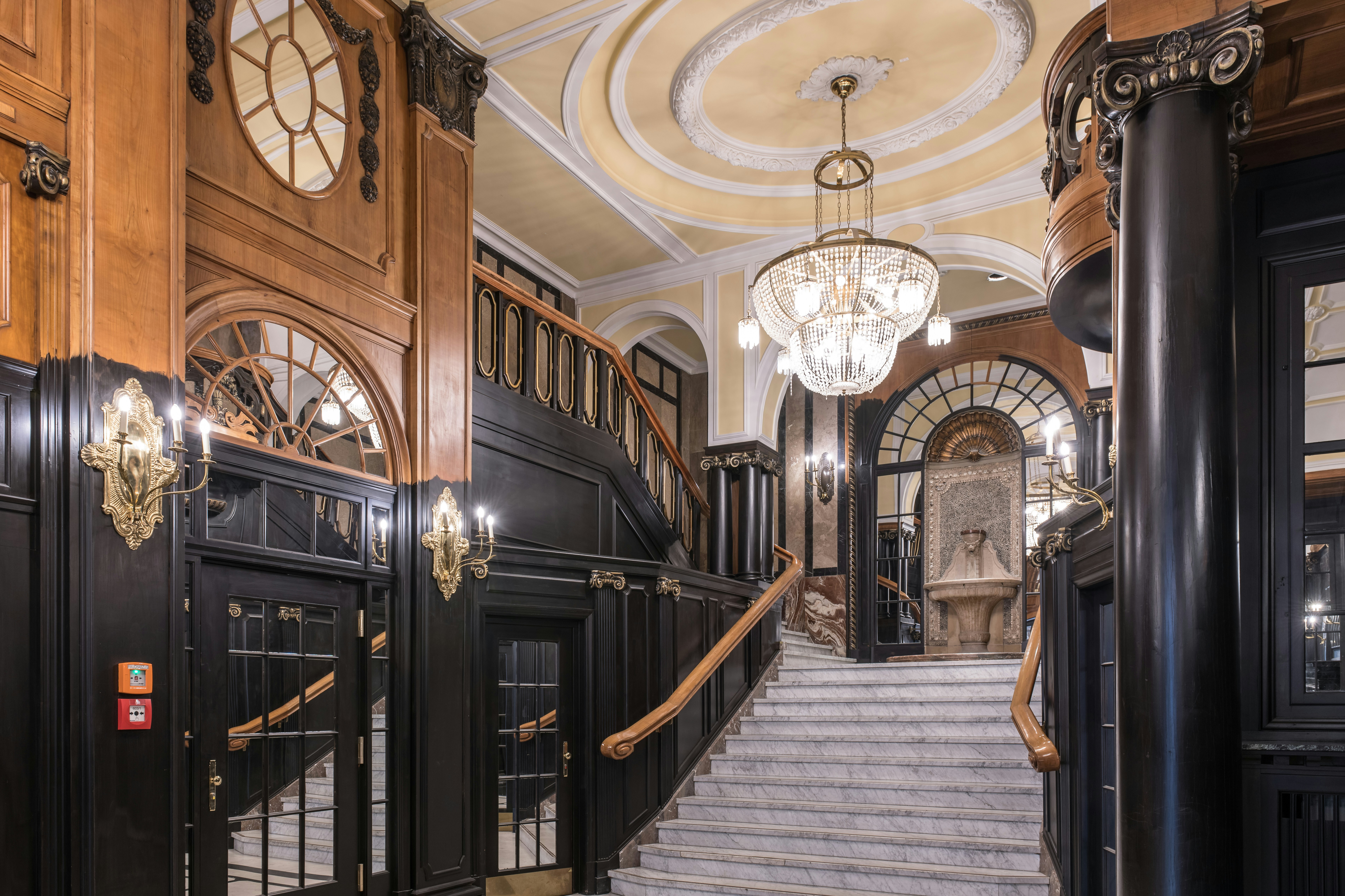 Ornate Stair Hall: A Marble Staircase Ascends under a Crystal Crown
