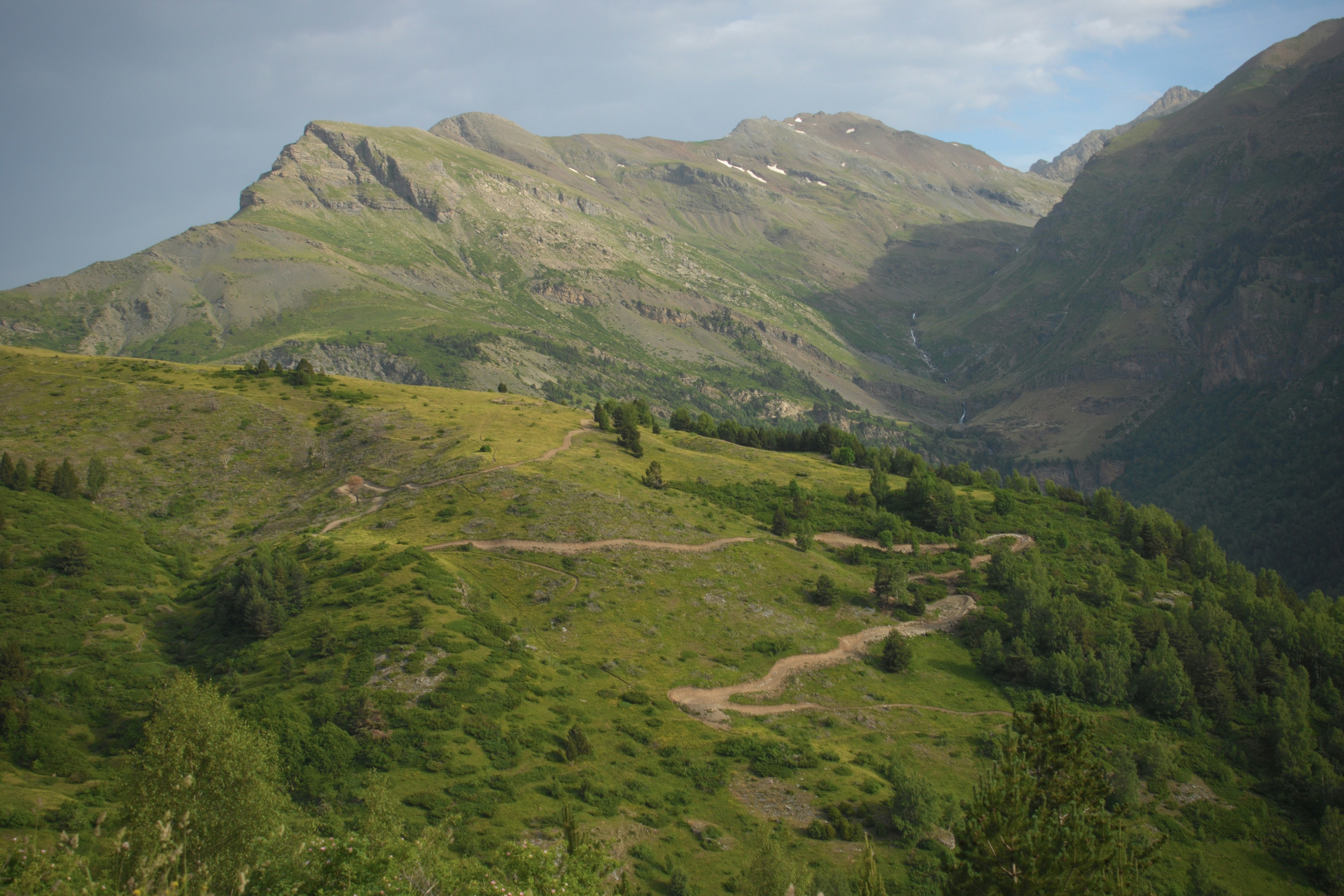 Verdant Basin Under Skyscapes: A Quiet Mountain Ascent