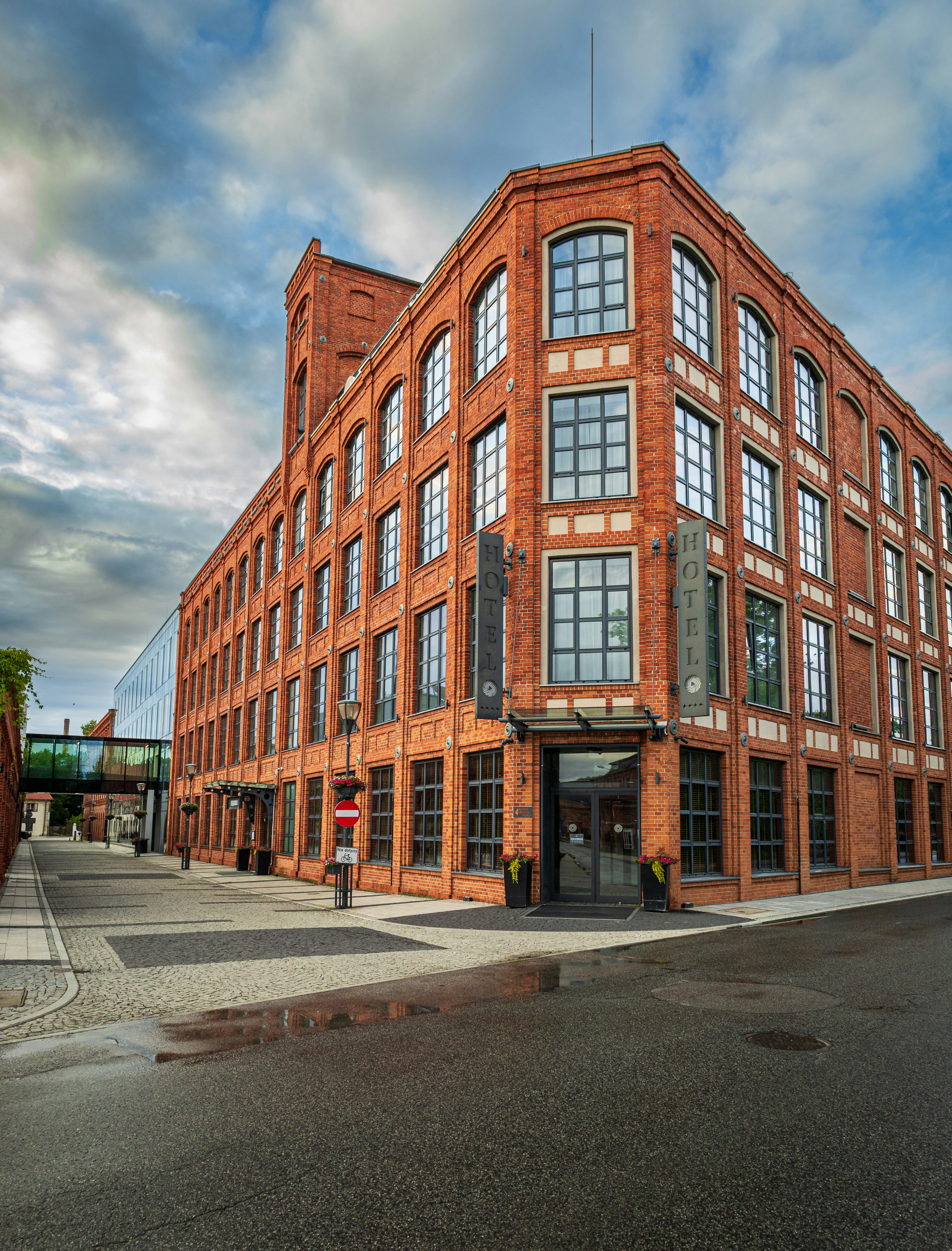 Historic Red Brick Industrial Hotel, Pabianice, Poland. Historic red brick industrial architecture in Pabianice, Poland, showcasing a restored complex adapted for contemporary hospitality use. The building preserves its industrial character while integrating modern architectural elements.