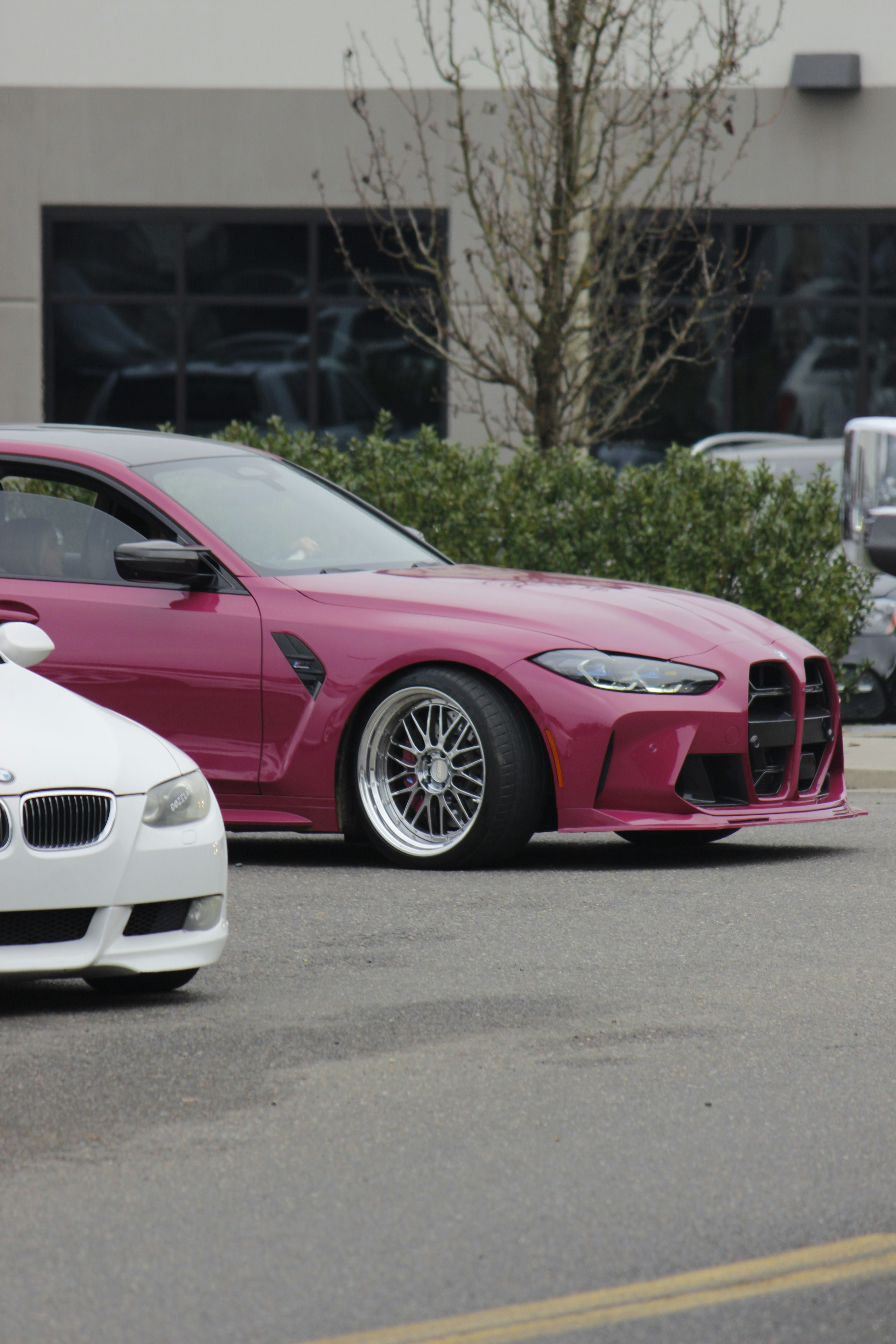 Crimson Ballet: A Low-Profile View of a Magenta BMW M8 in a Parking Lot