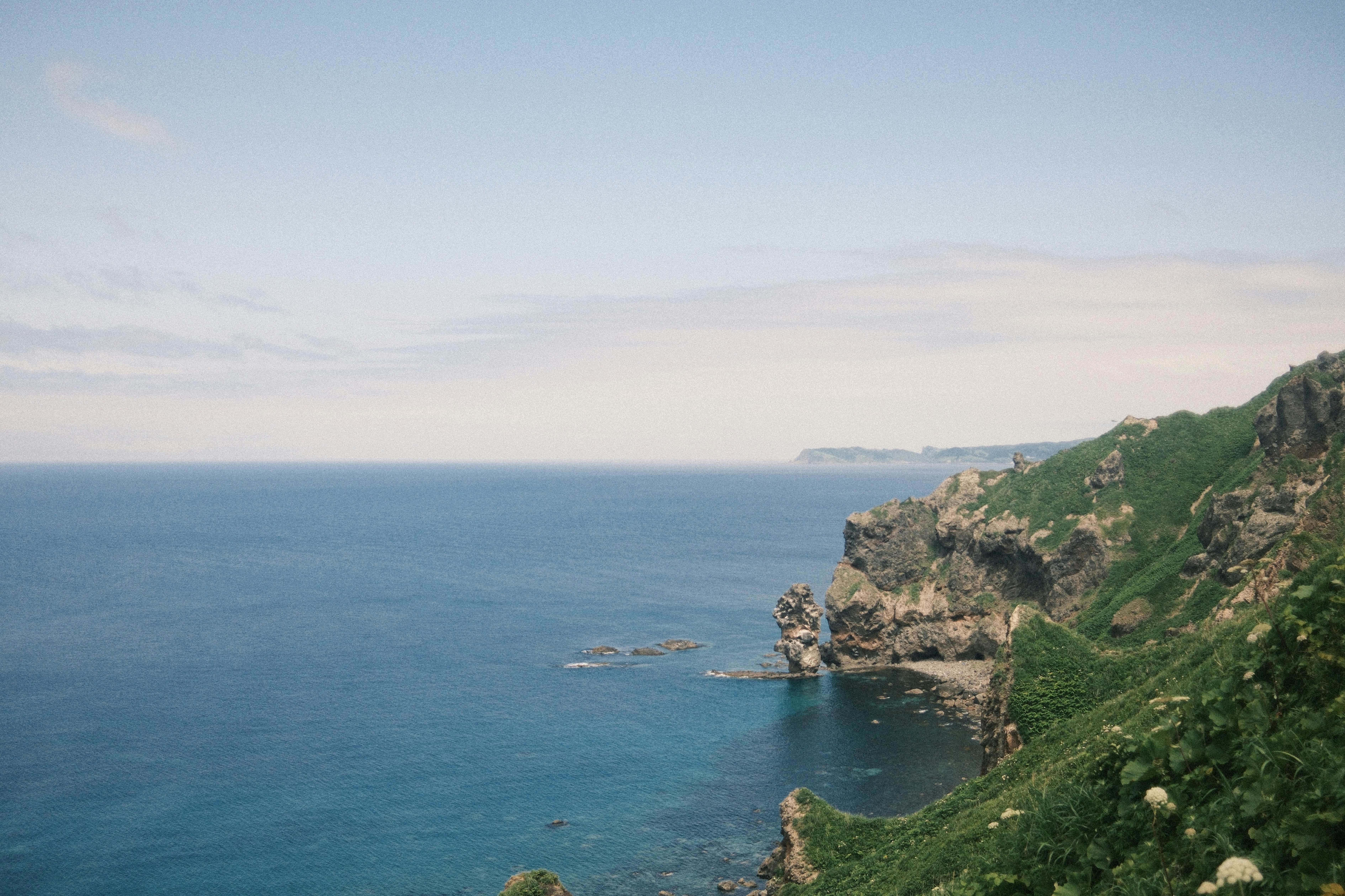Cliffside Vista: Clearsky Coastline over Azure Waters