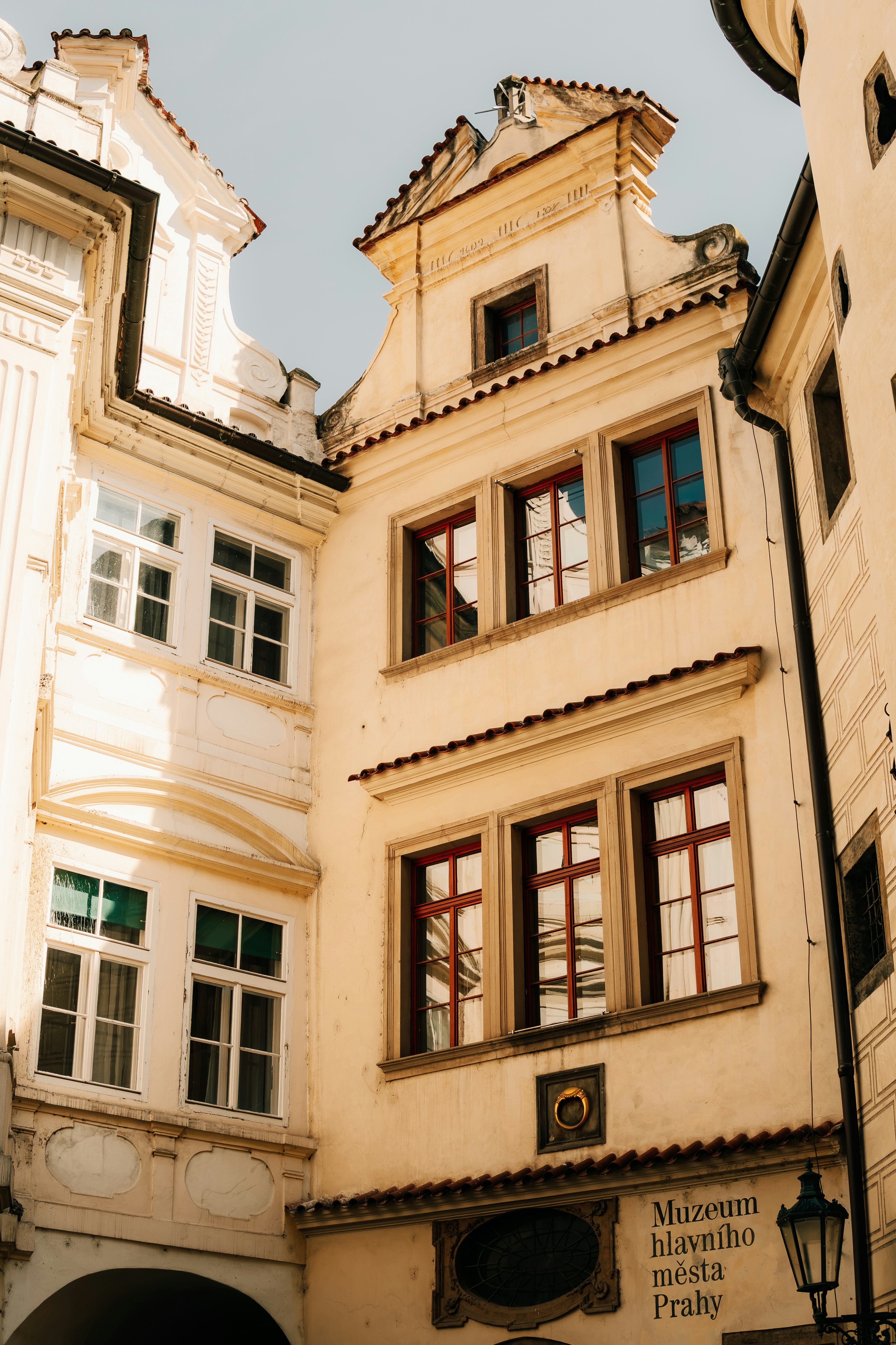 Historic Courtyard Façade: Sunlit Windows and The Prague Museum