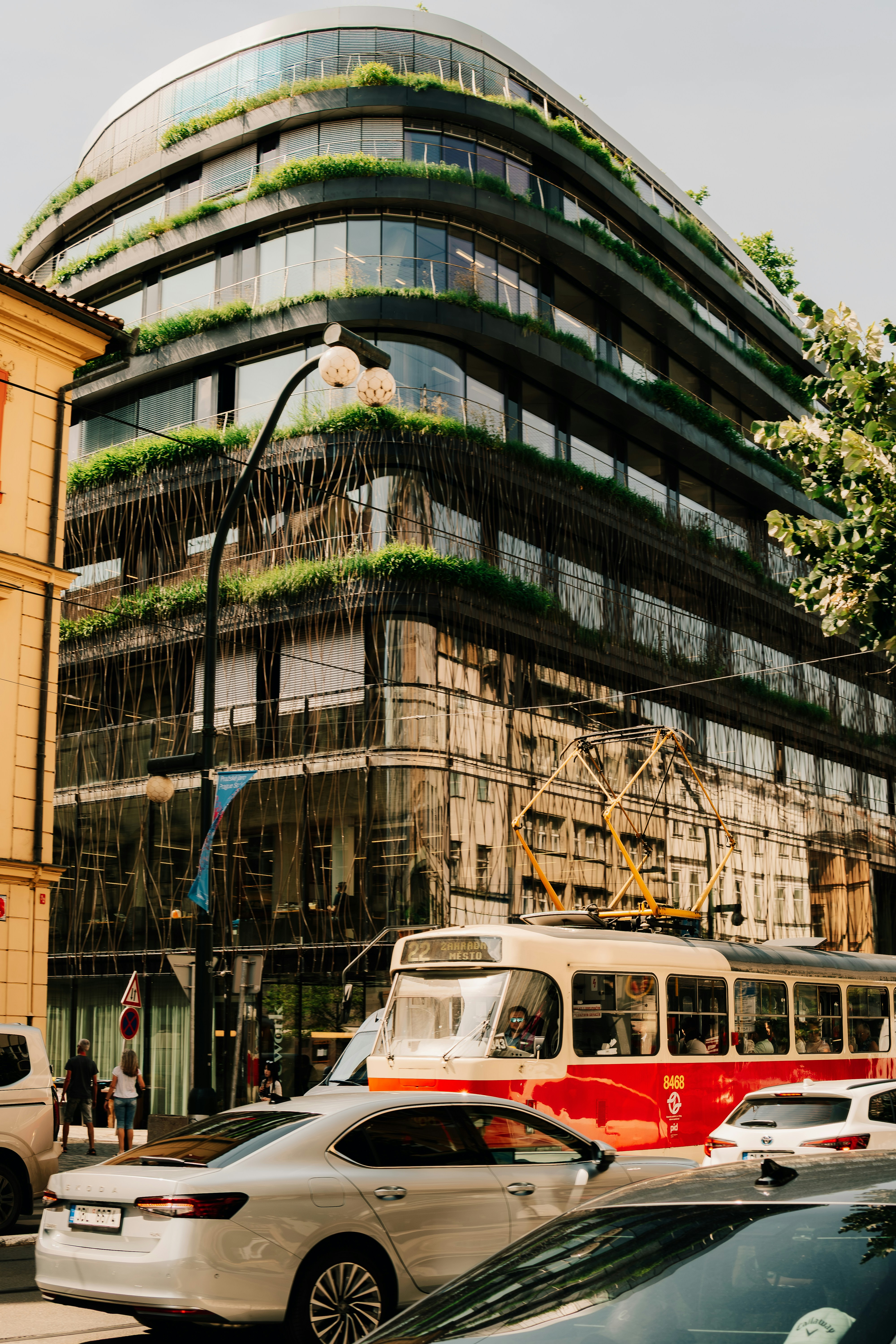 Green-floored façade: a curved modernist building rises over a bustling street