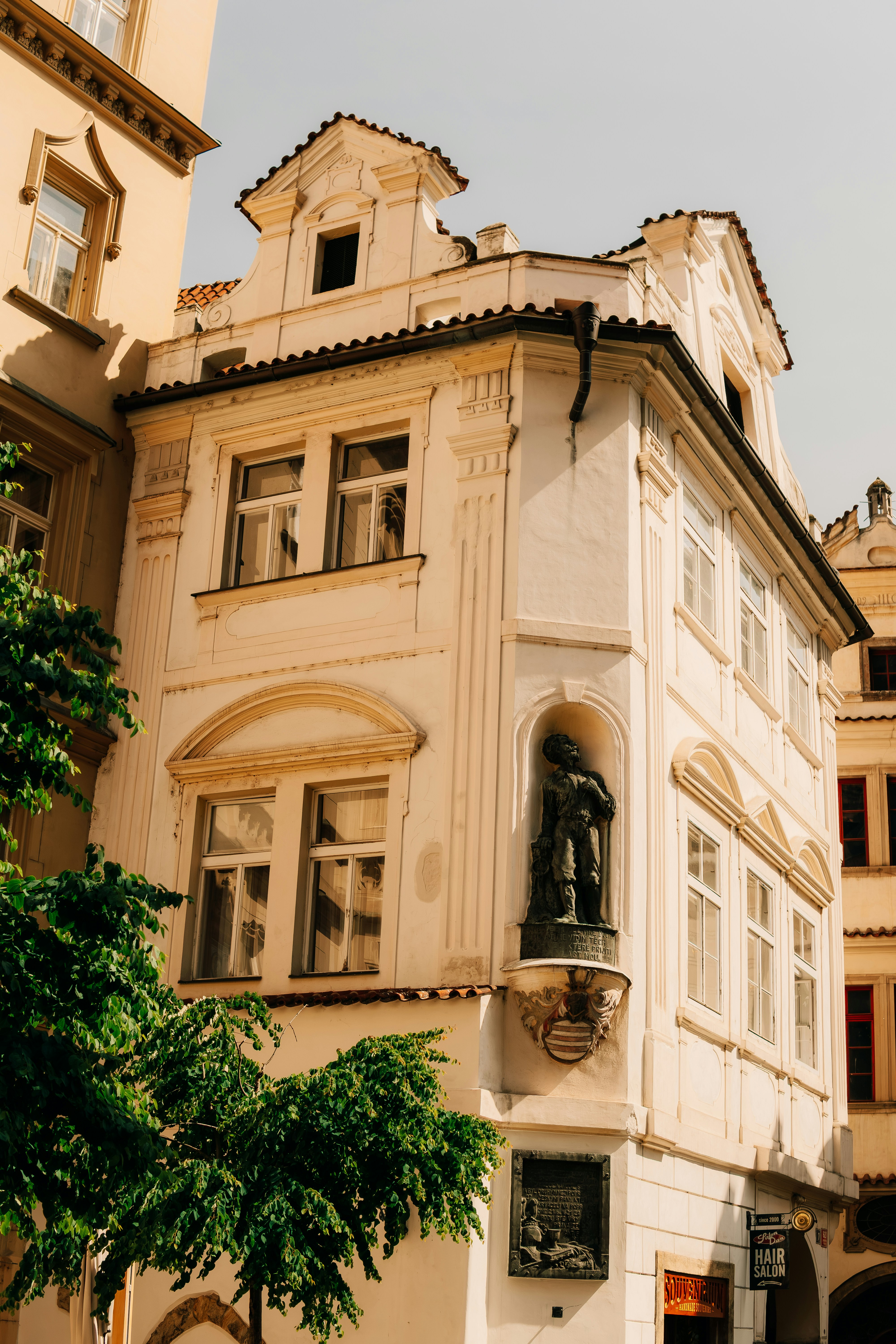 Sunlit Facade: Historic Corner Building with Statue