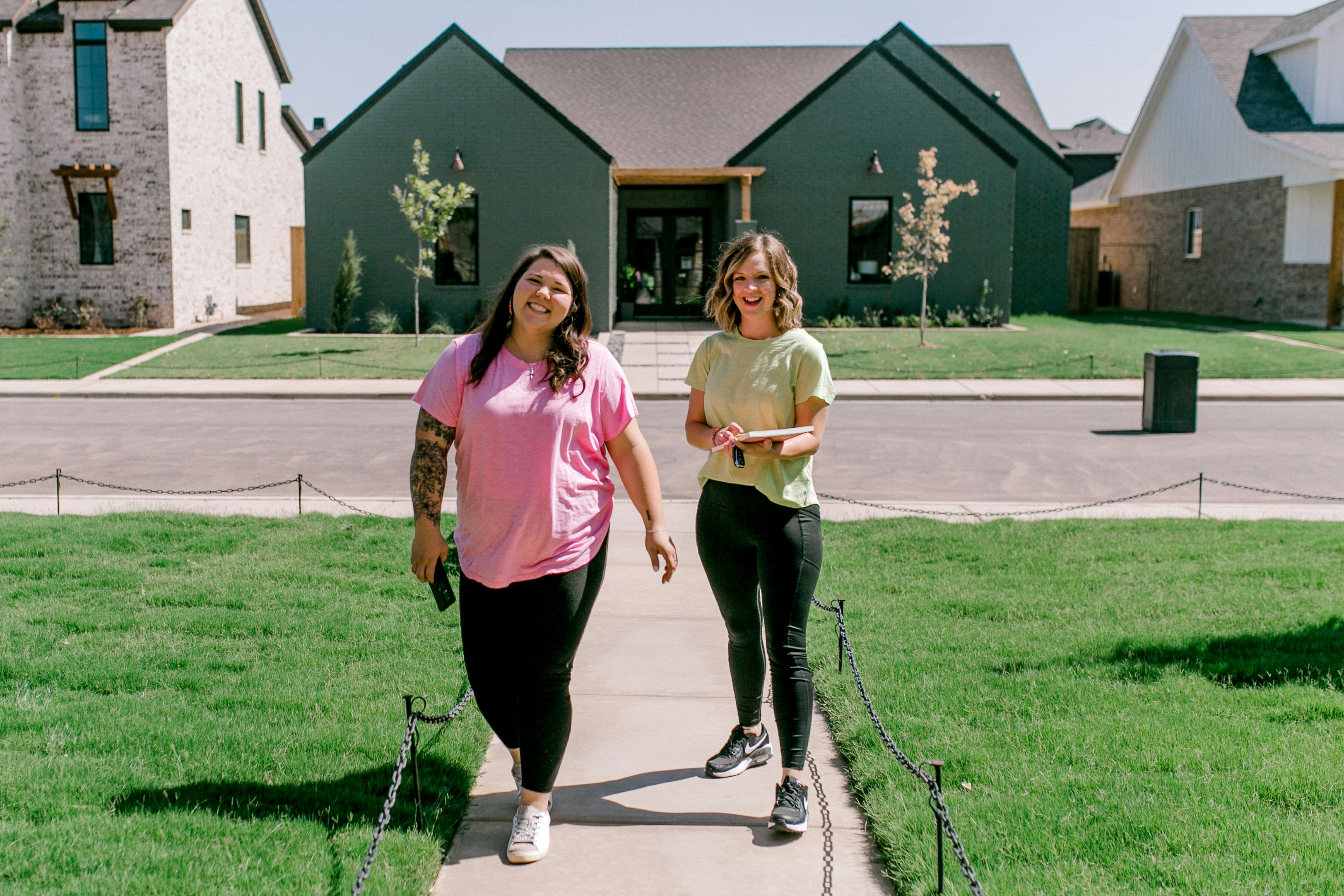 Two Friends Stroll Through a Modern Suburban Park