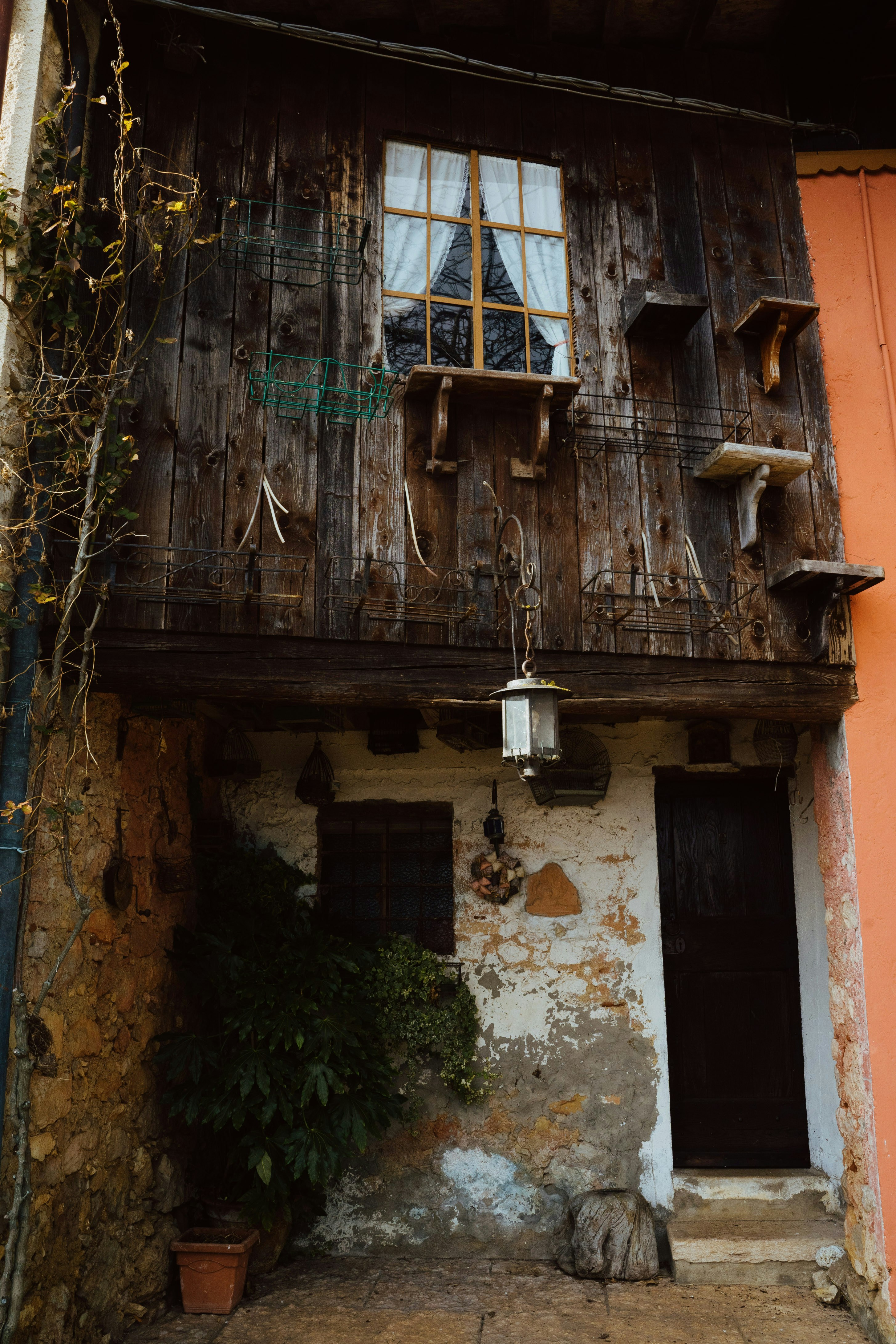 Weathered Cottage Gaze: A Window to the Attic Shadows