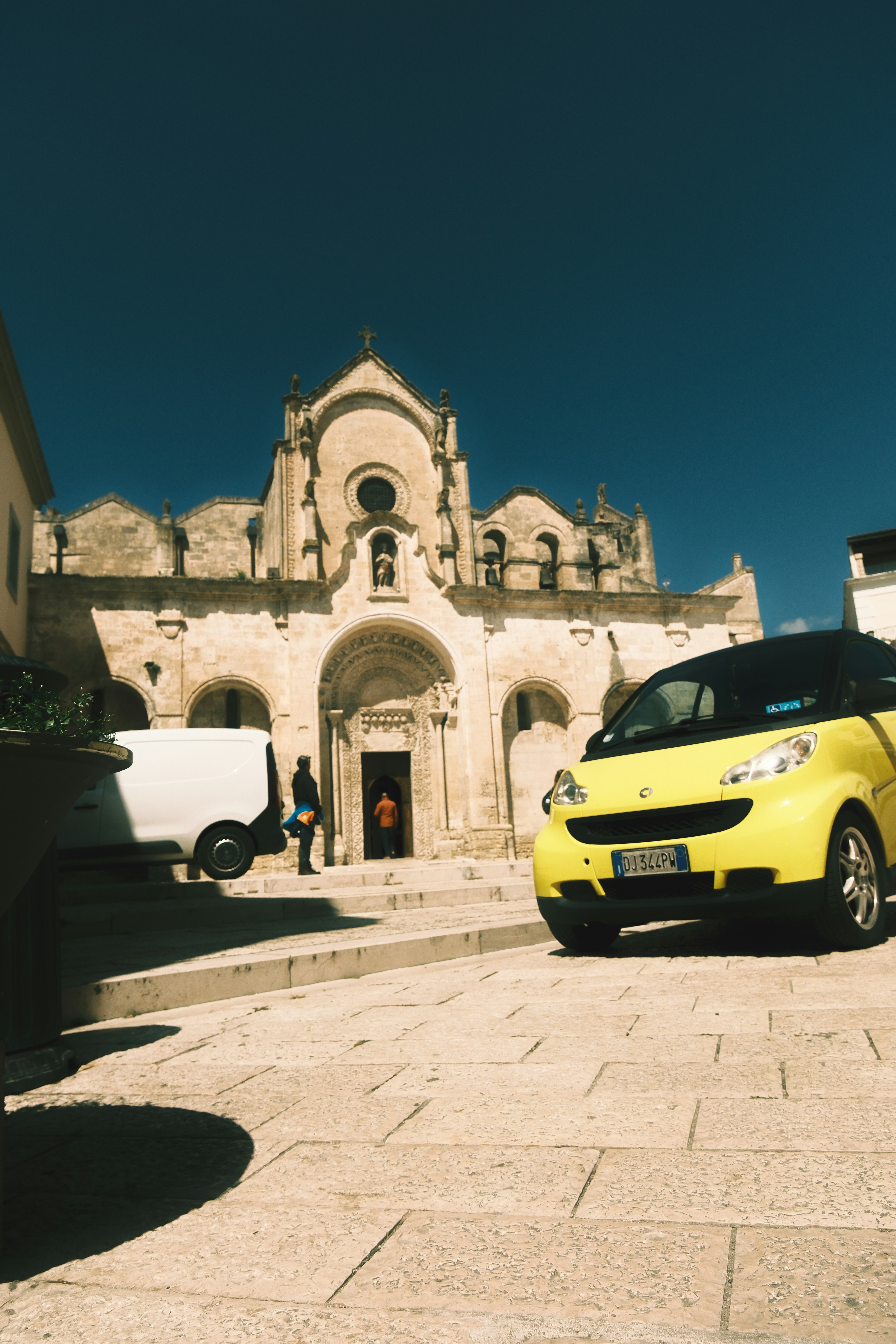 Sunlit Facade and the City's Bright Yellow Car