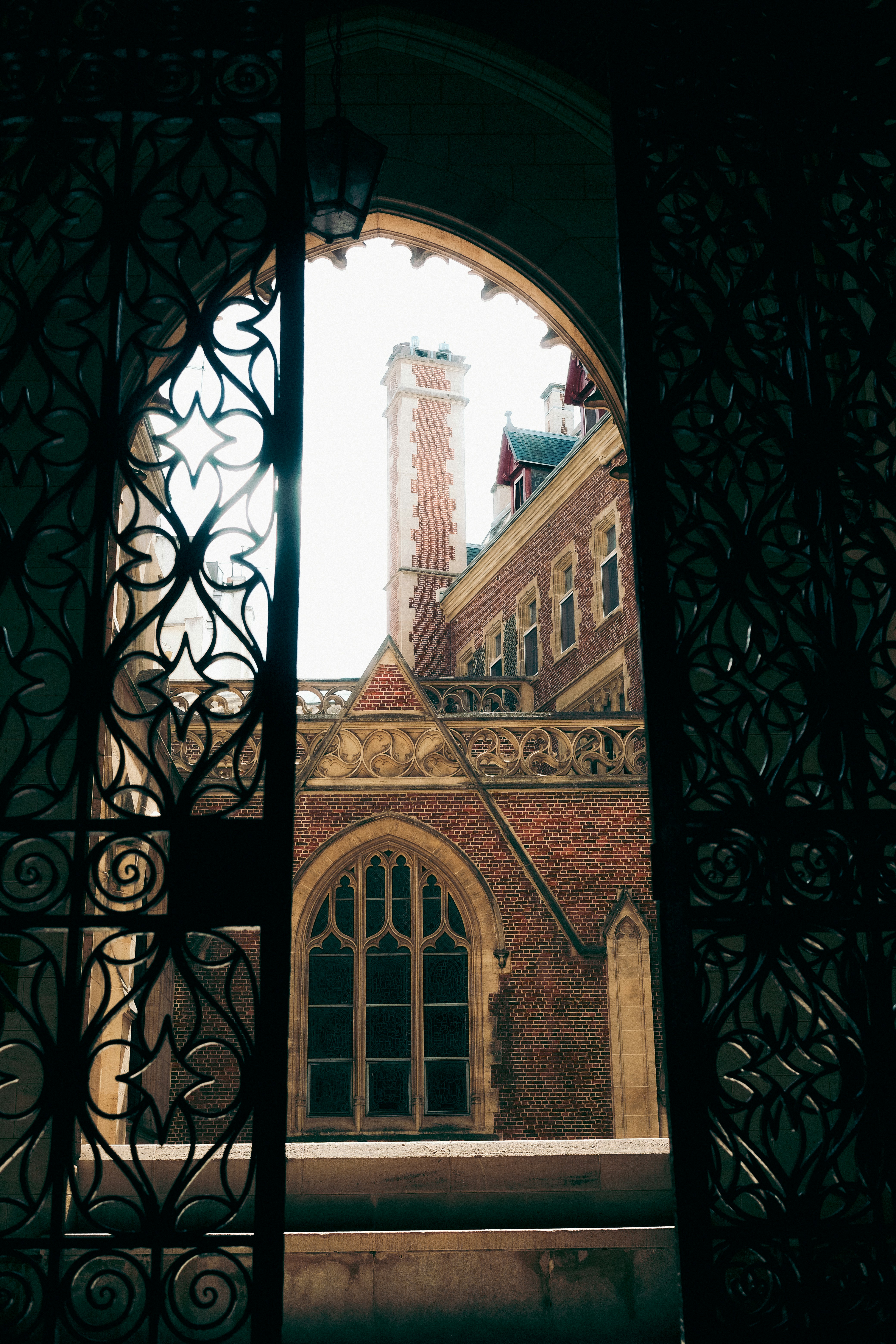 Ironwork Gateways and Gothic Courtyard Through a Narrow Arch