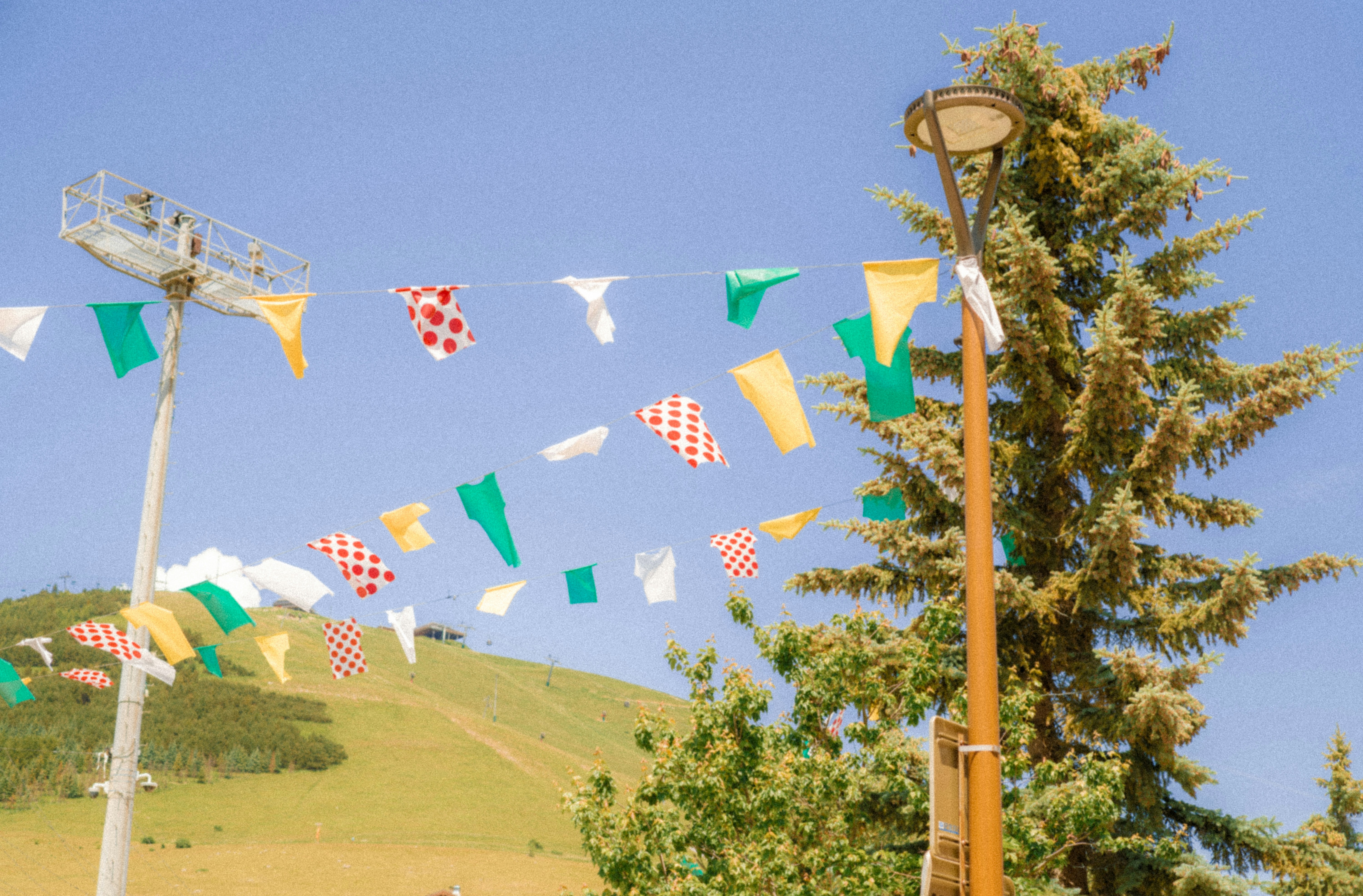 Colorful Flags Dancing Between Sky and Hill
