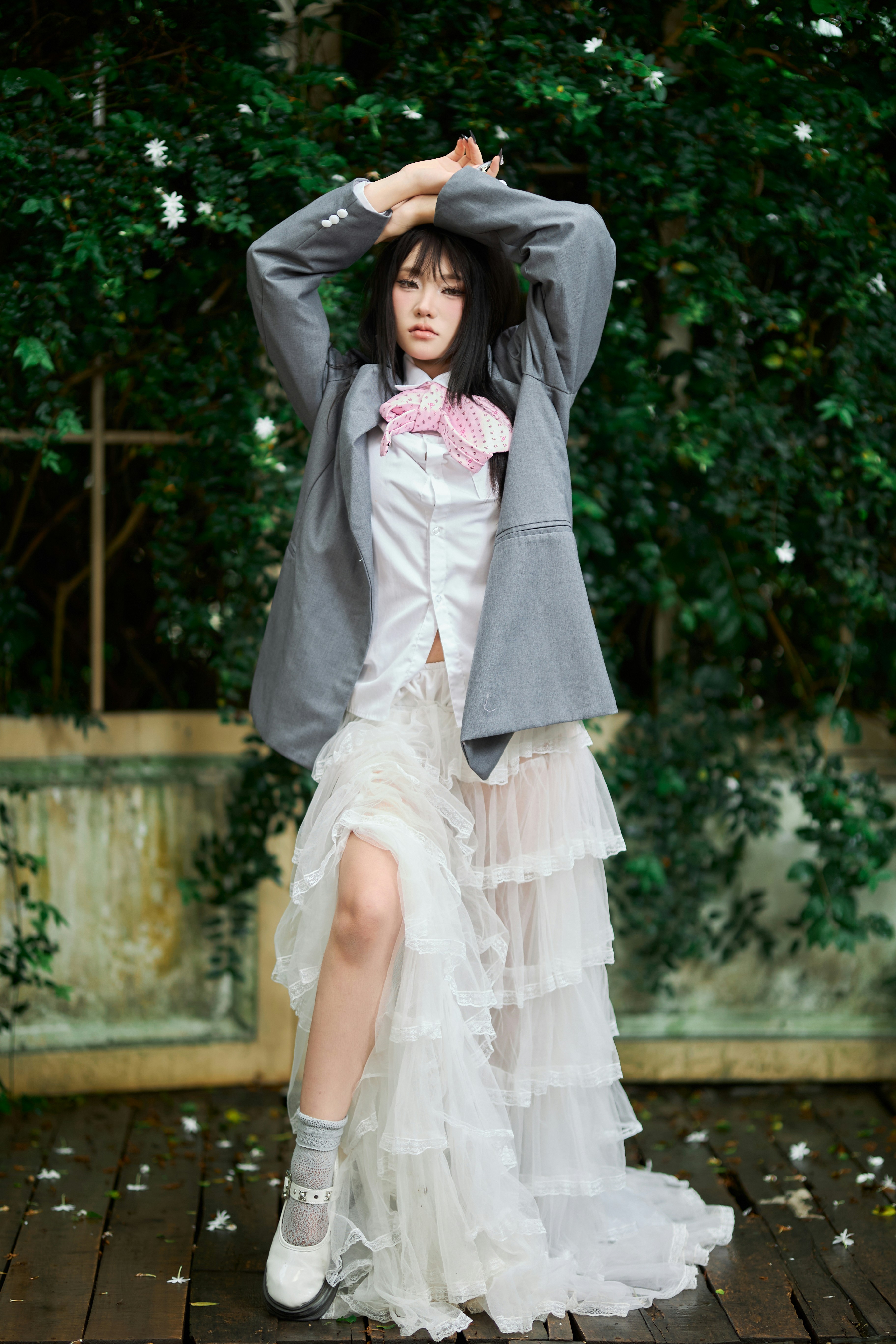 Grey blazer, pink bow, and tiered veil: a garden pose in motion