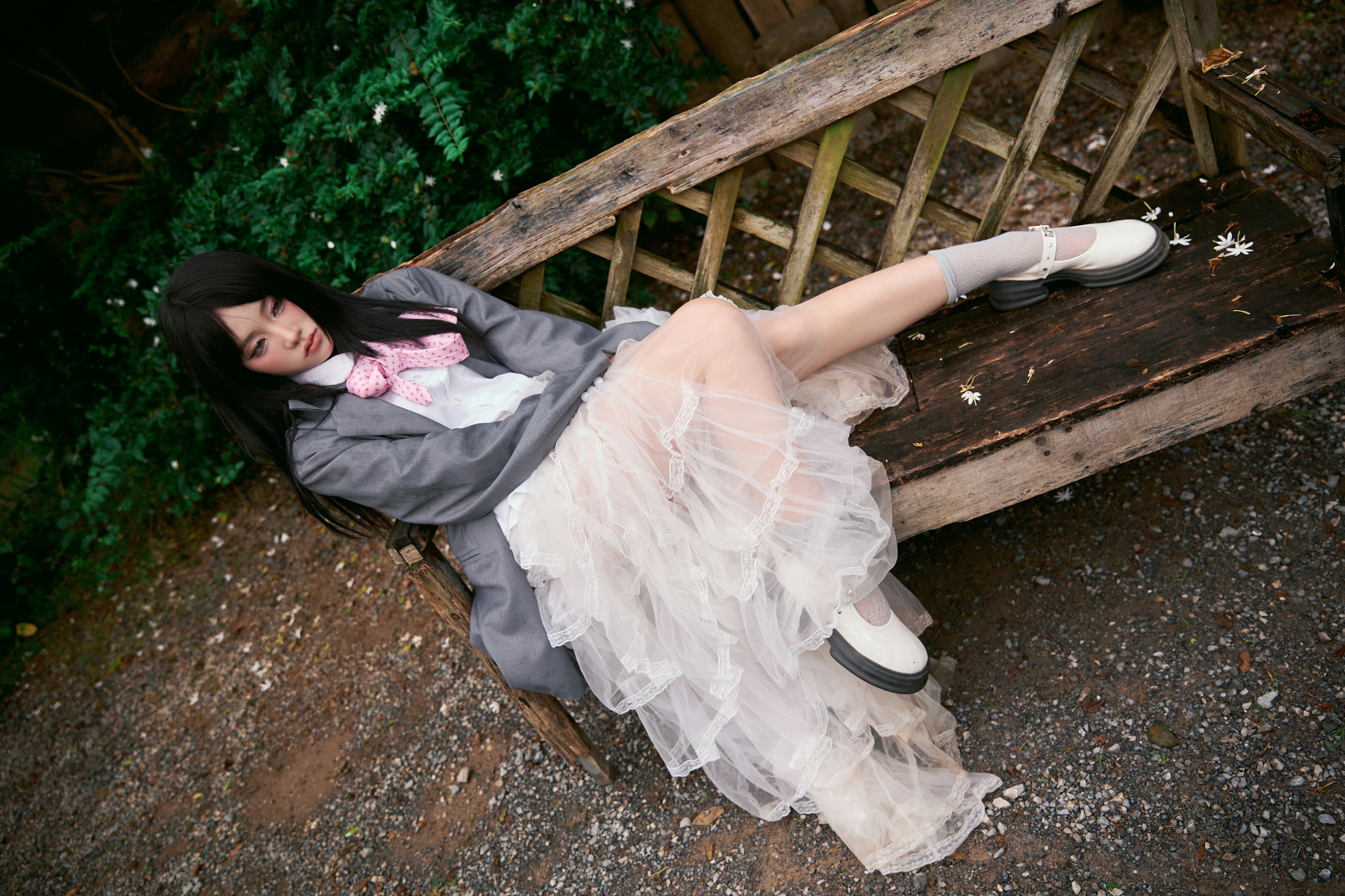 Girl in a Soft Doll Skirt Resting on a Weathered Bench
