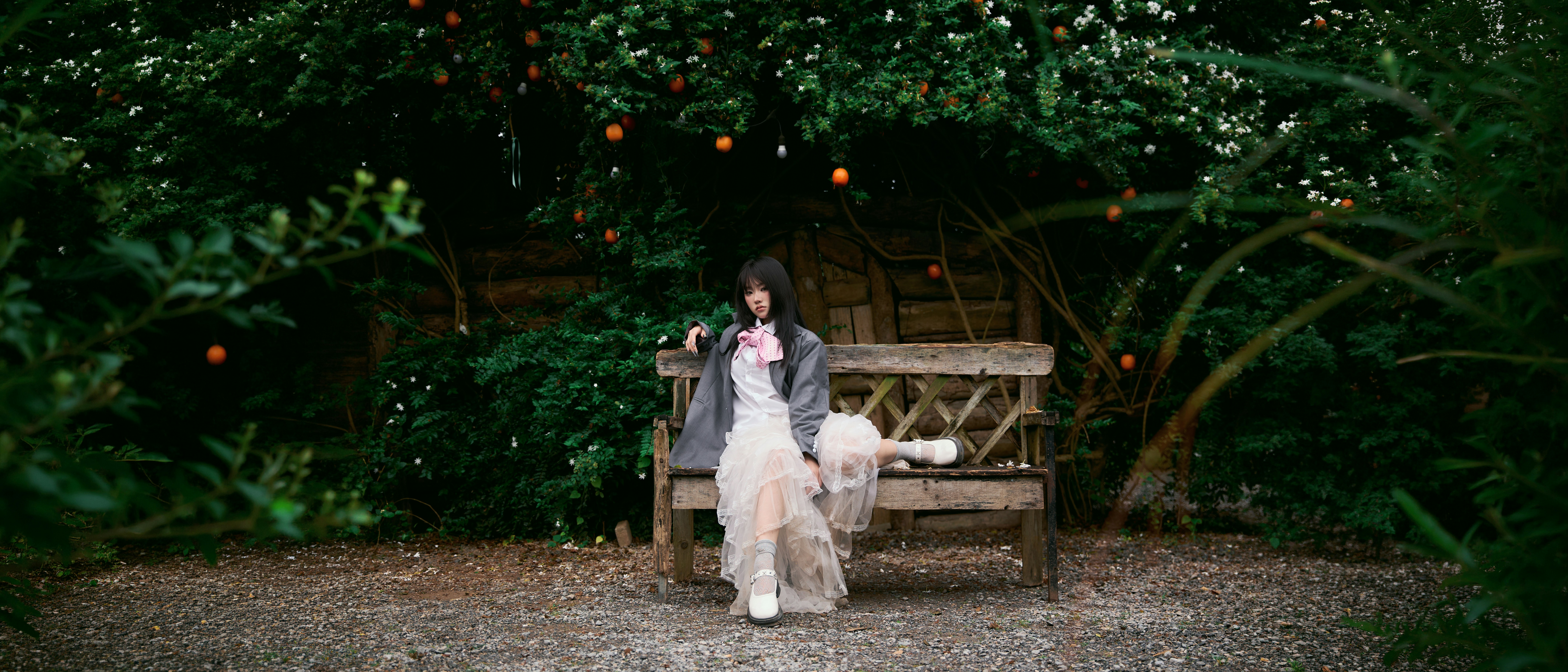 Girl on a wooden bench under a blooming canopy