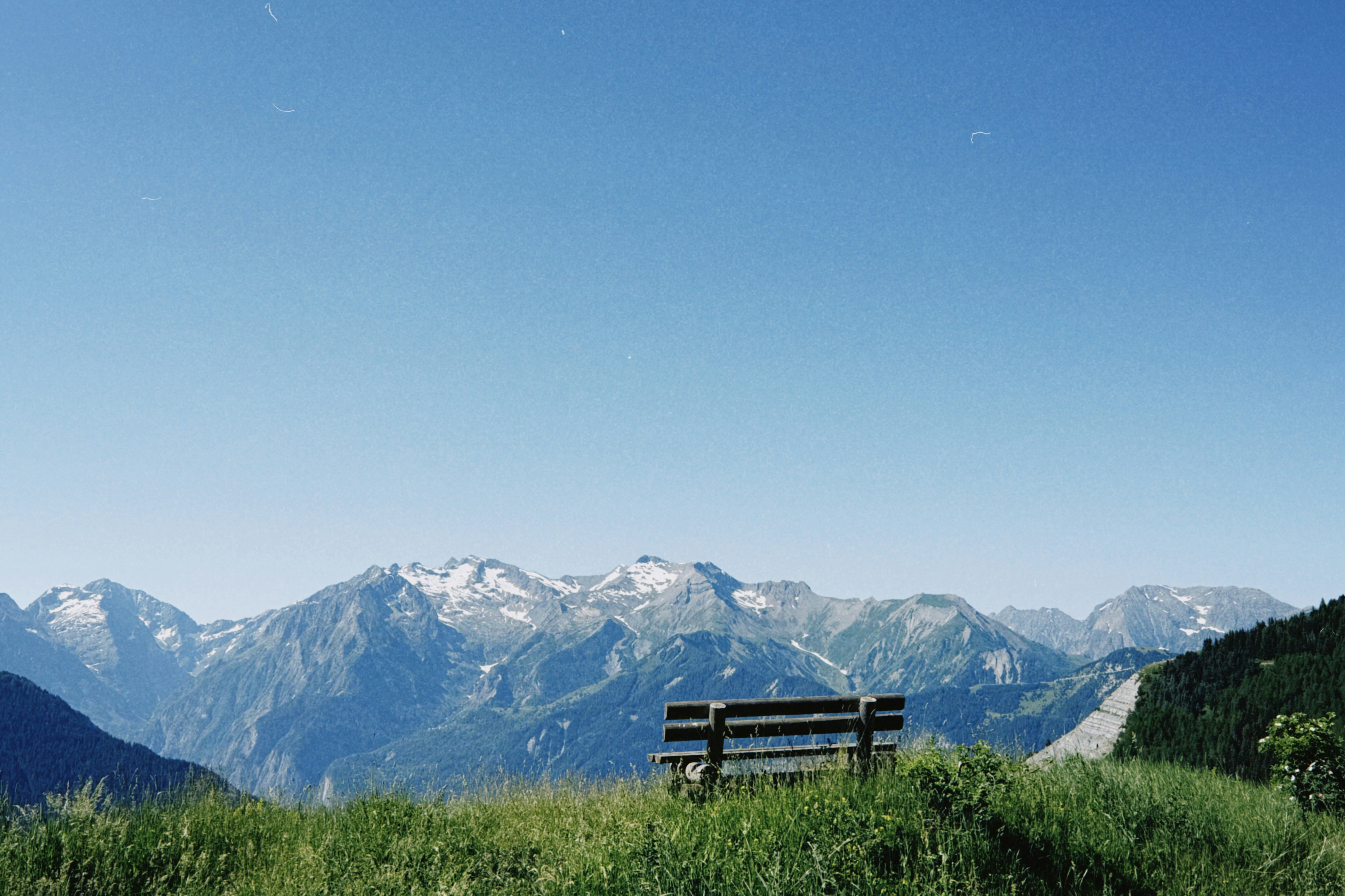 Bench Beneath the Ridge: Quiet Vista of Alpine Peaks