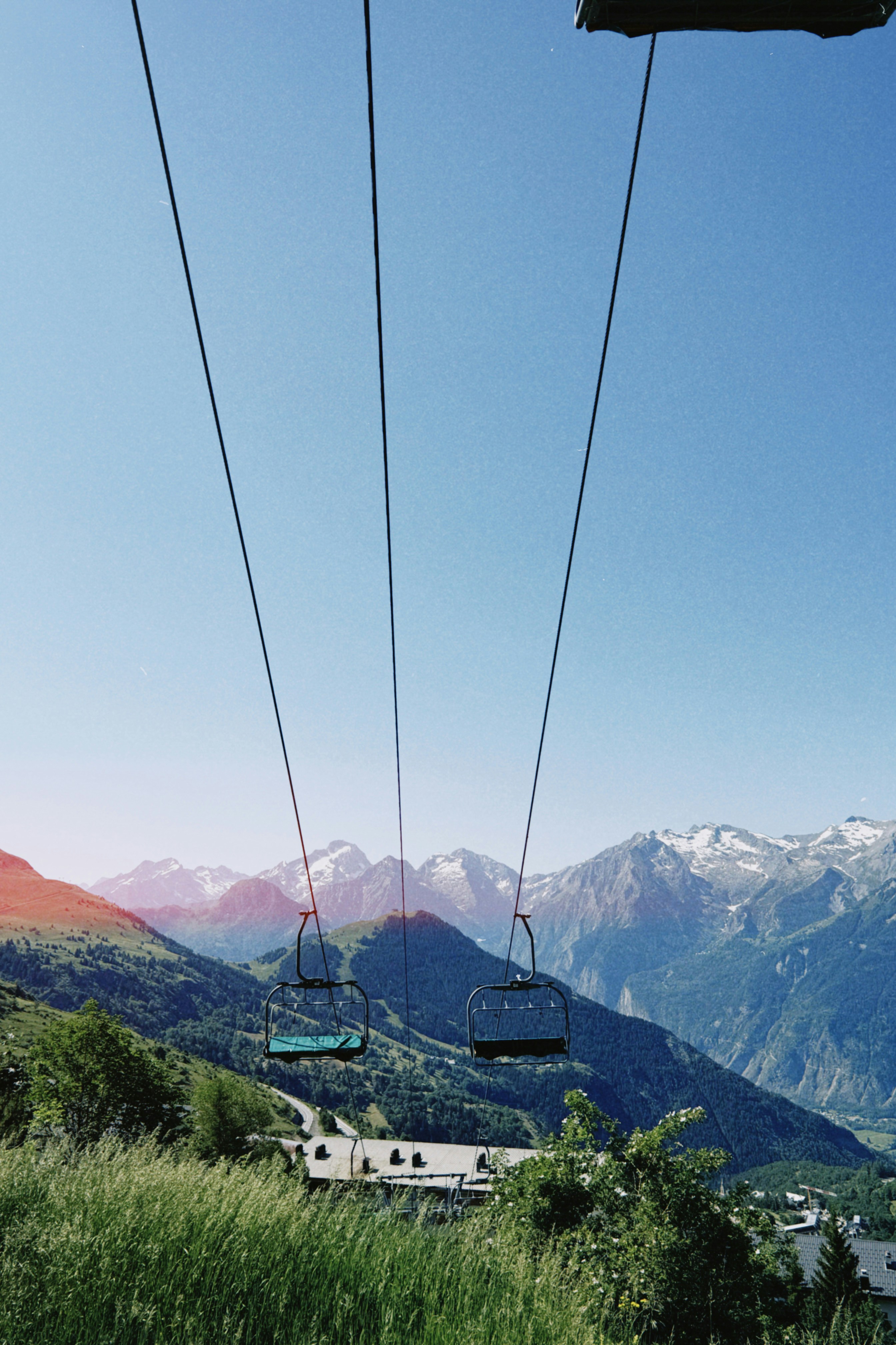Cable Car Silhouette Over Alpine Treetops at Noon