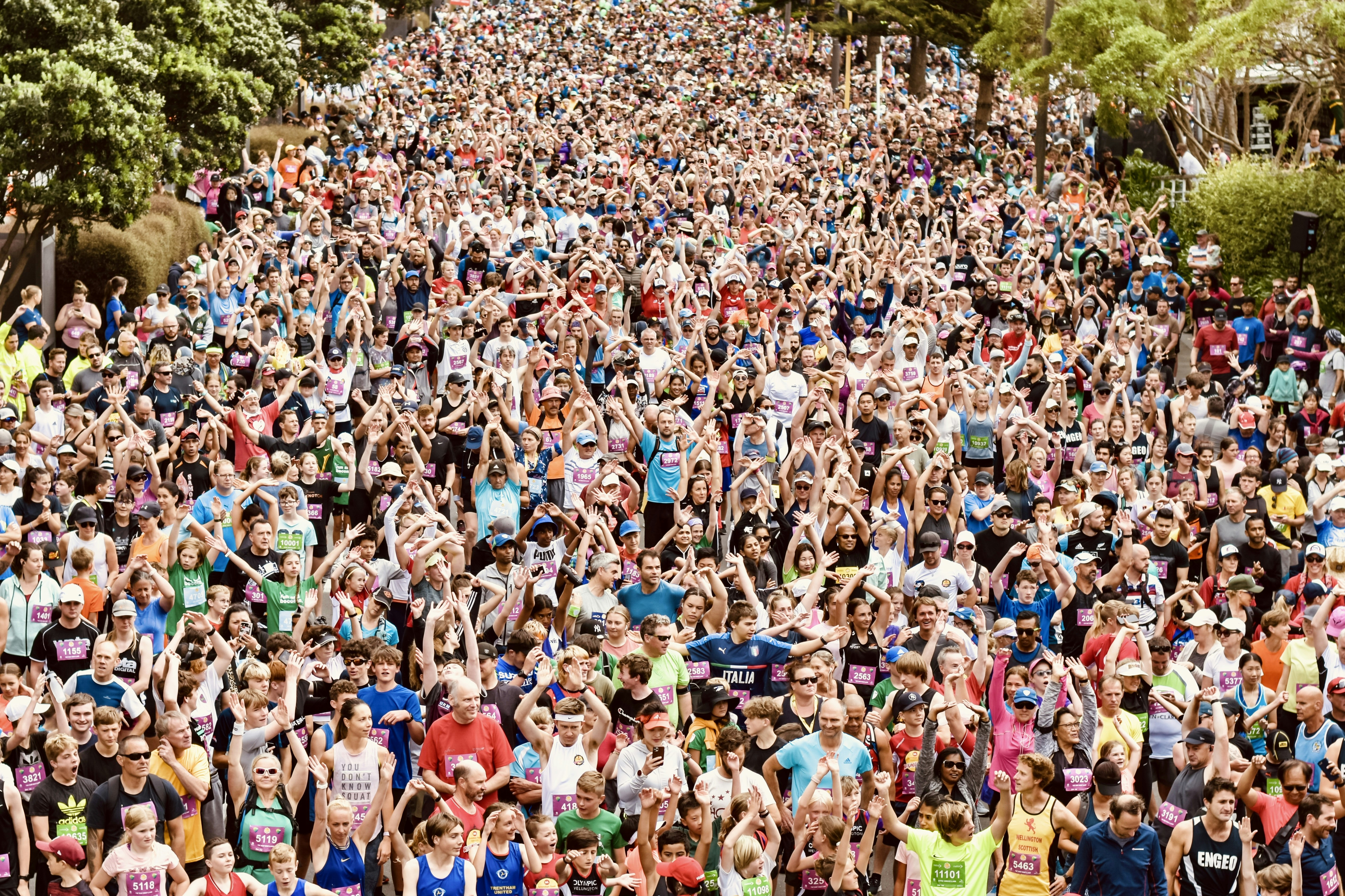 Mass of runners raising hands at the finish line