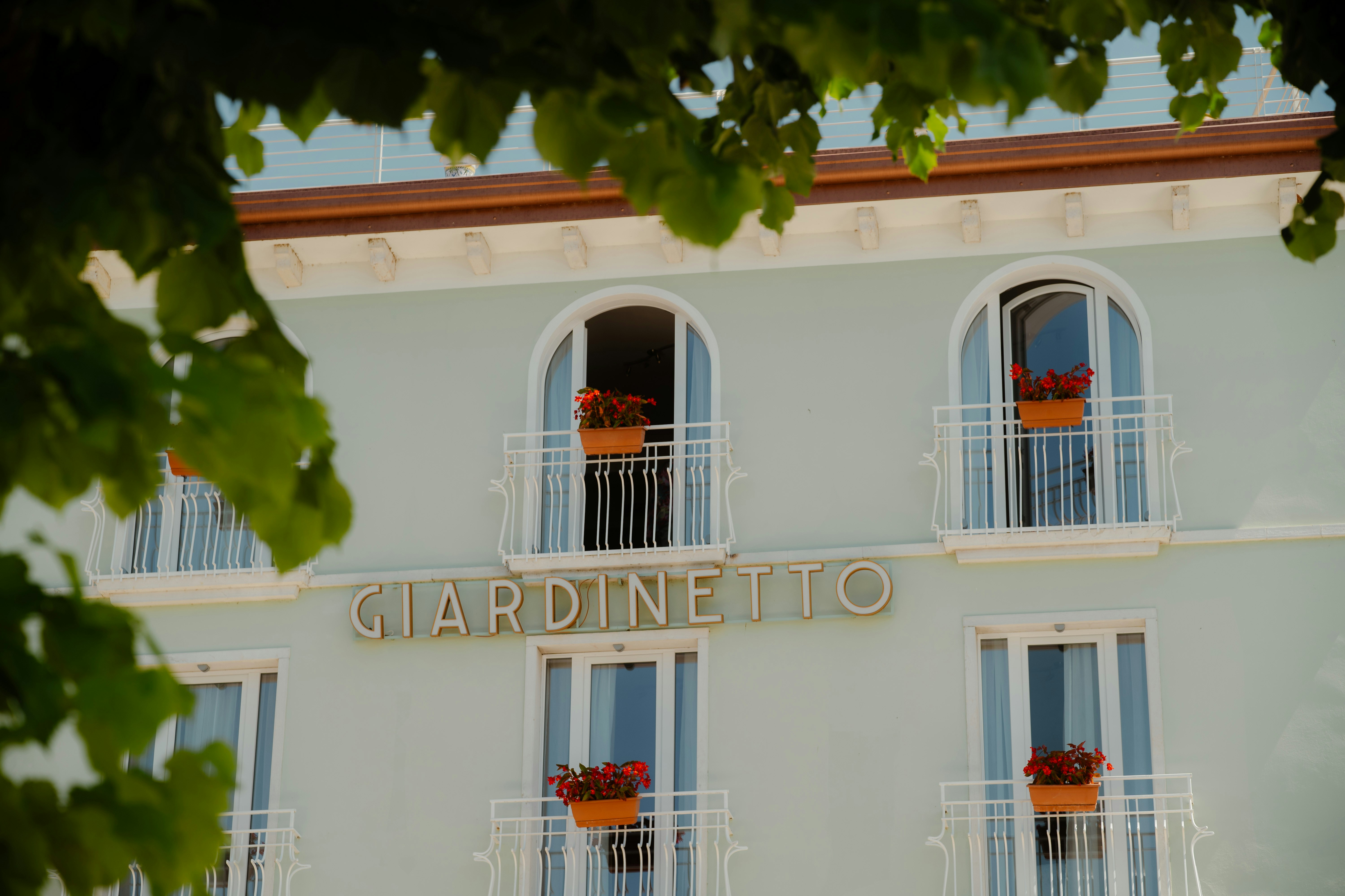 Balcony Blooms Over a pastel Facade