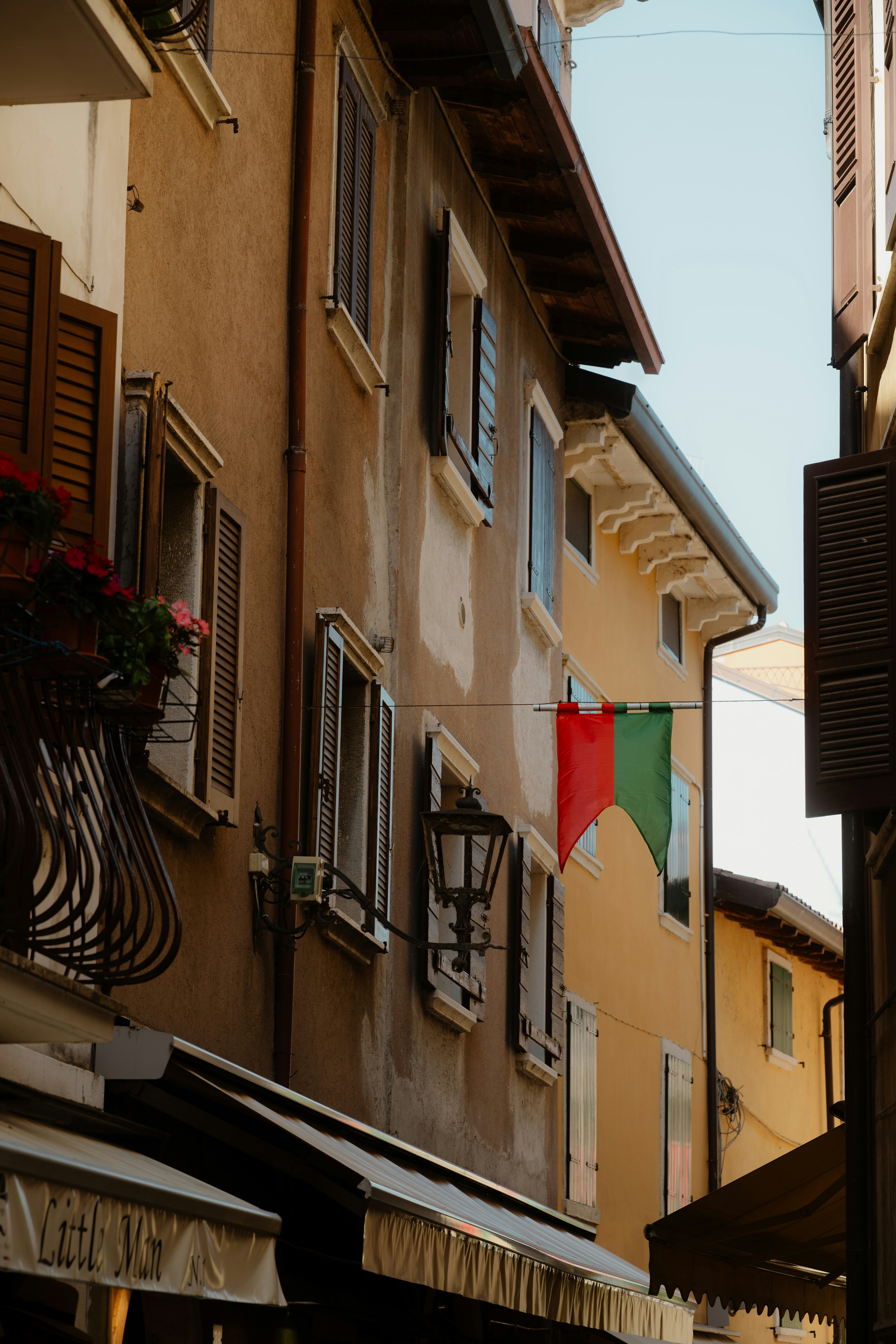 Sunlit Italian Alleyway with Tricolor Banner