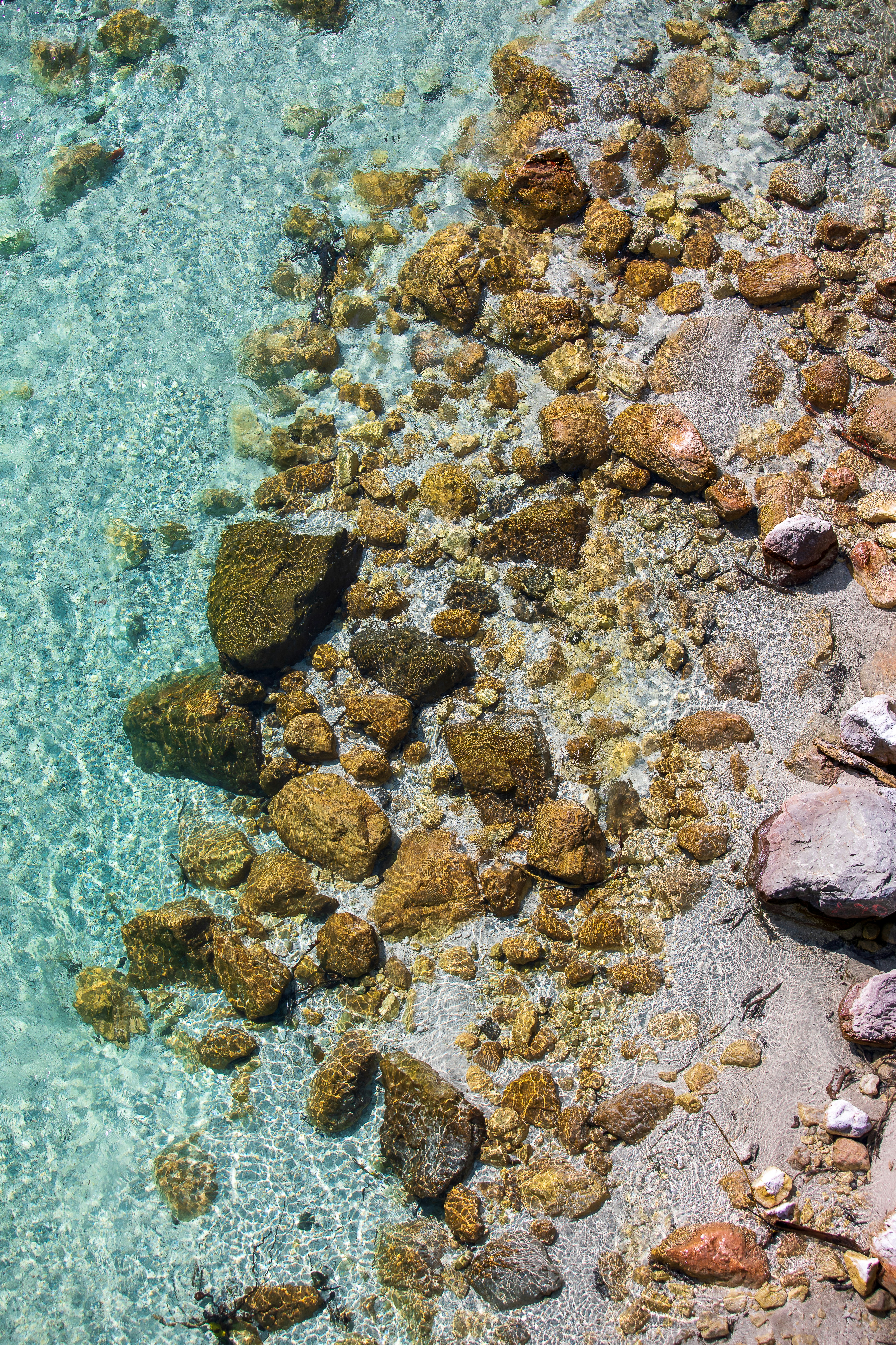 Ashore Shimmer: Pebbles and Turquoise Tides