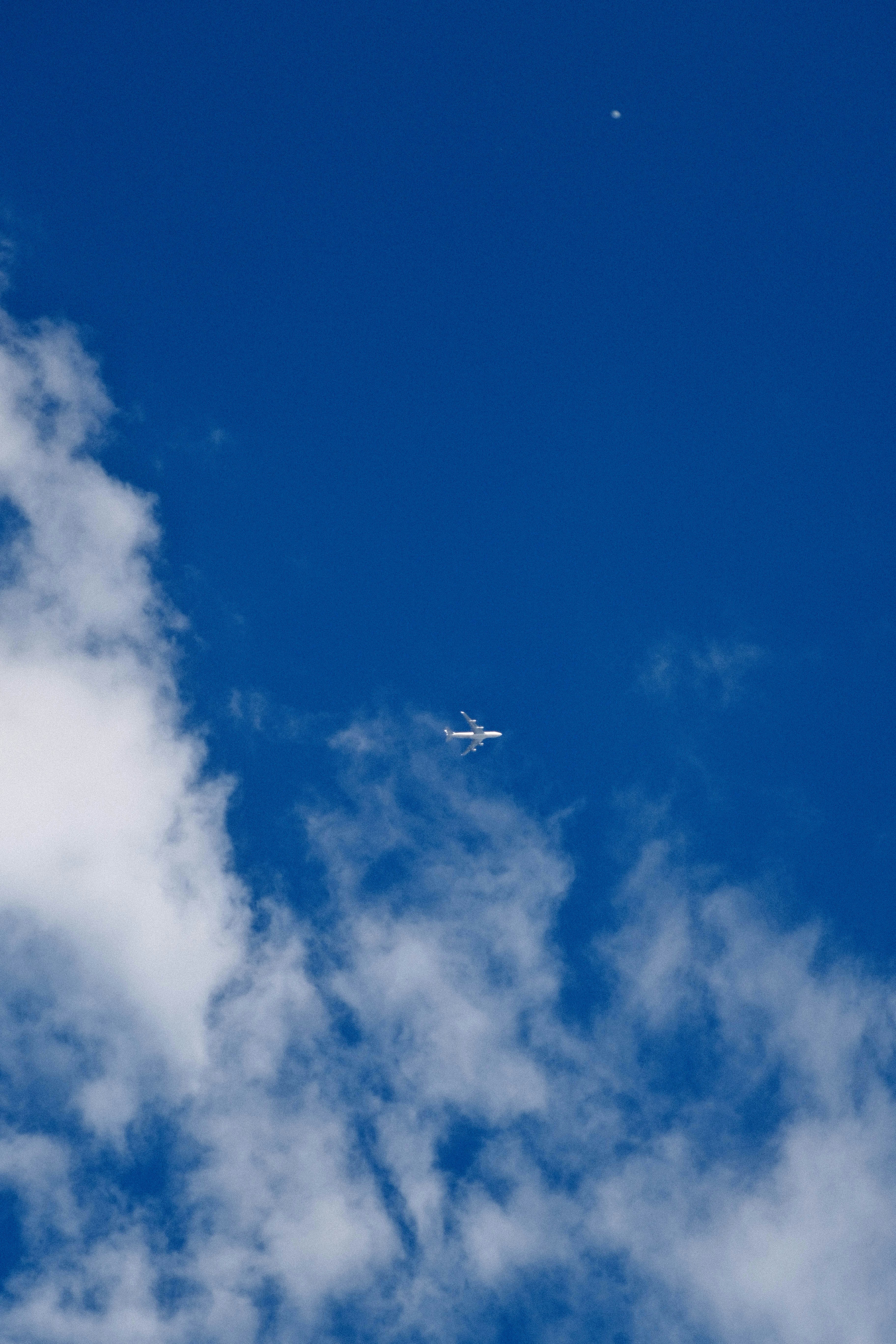 Visible passenger jet cutting through a bright afternoon sky