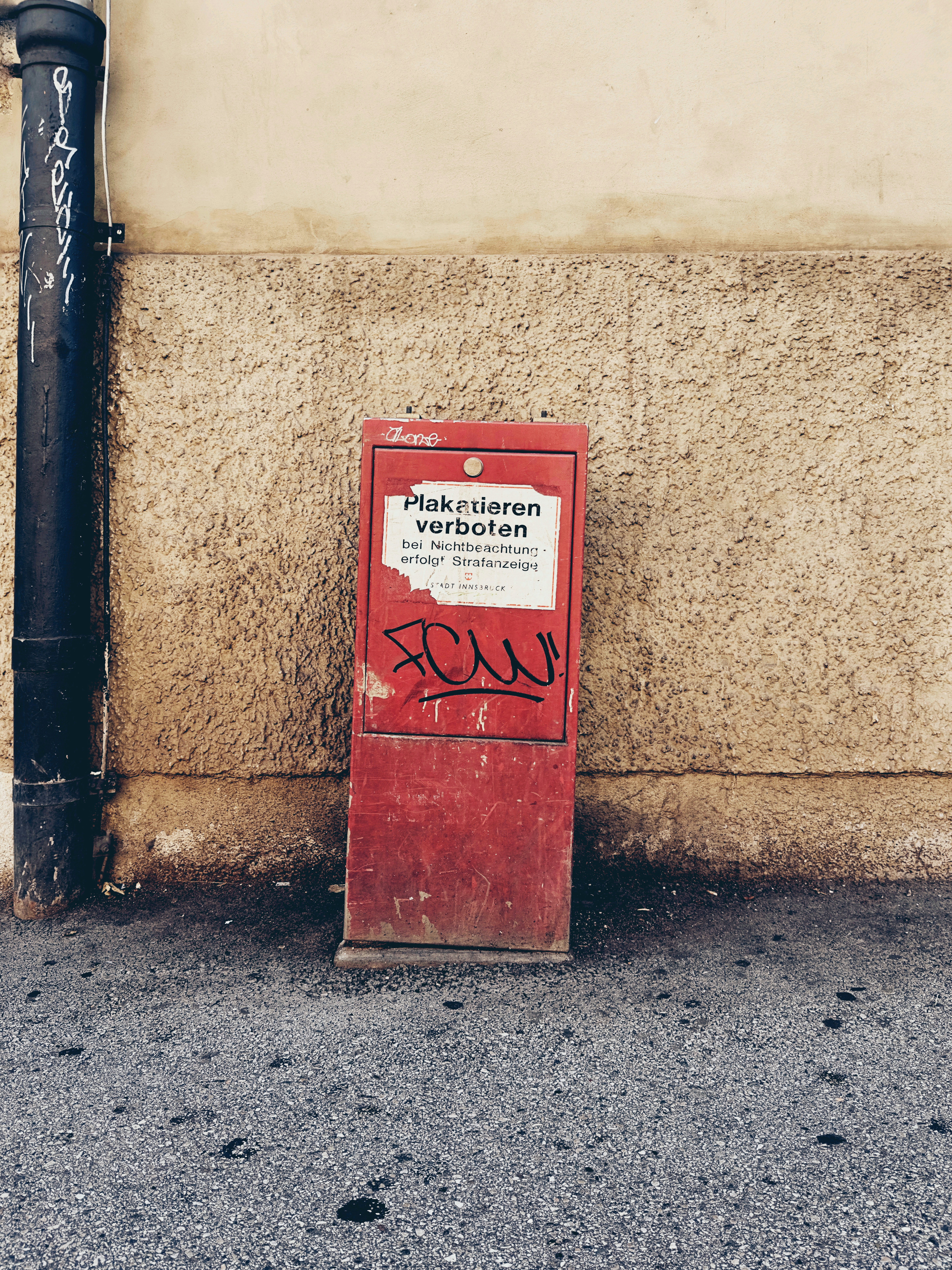 Red Mailbox on Weathered Wall with Graffiti