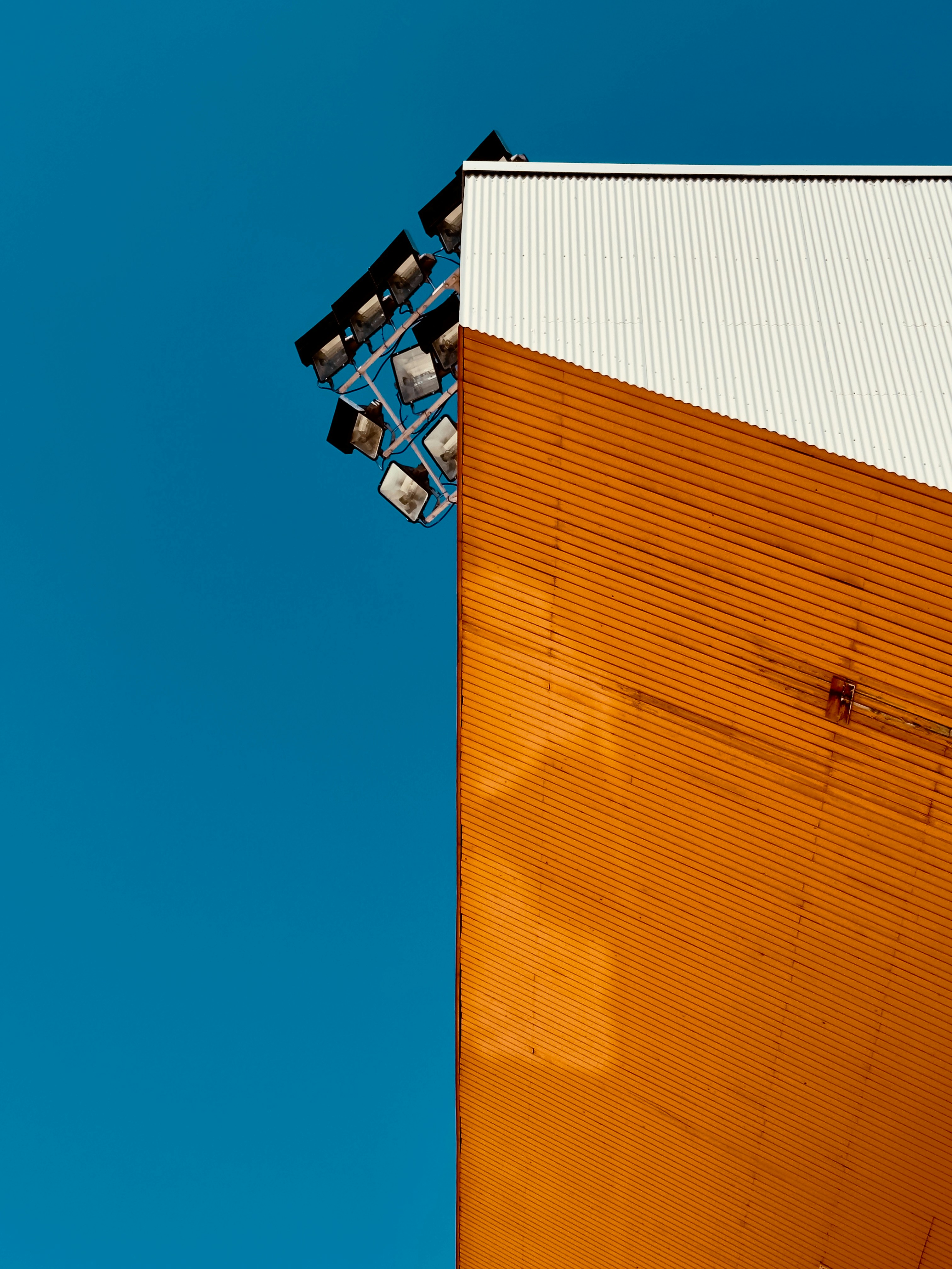 Corner of Orange Steel: A Geometric Moment against Blue Sky