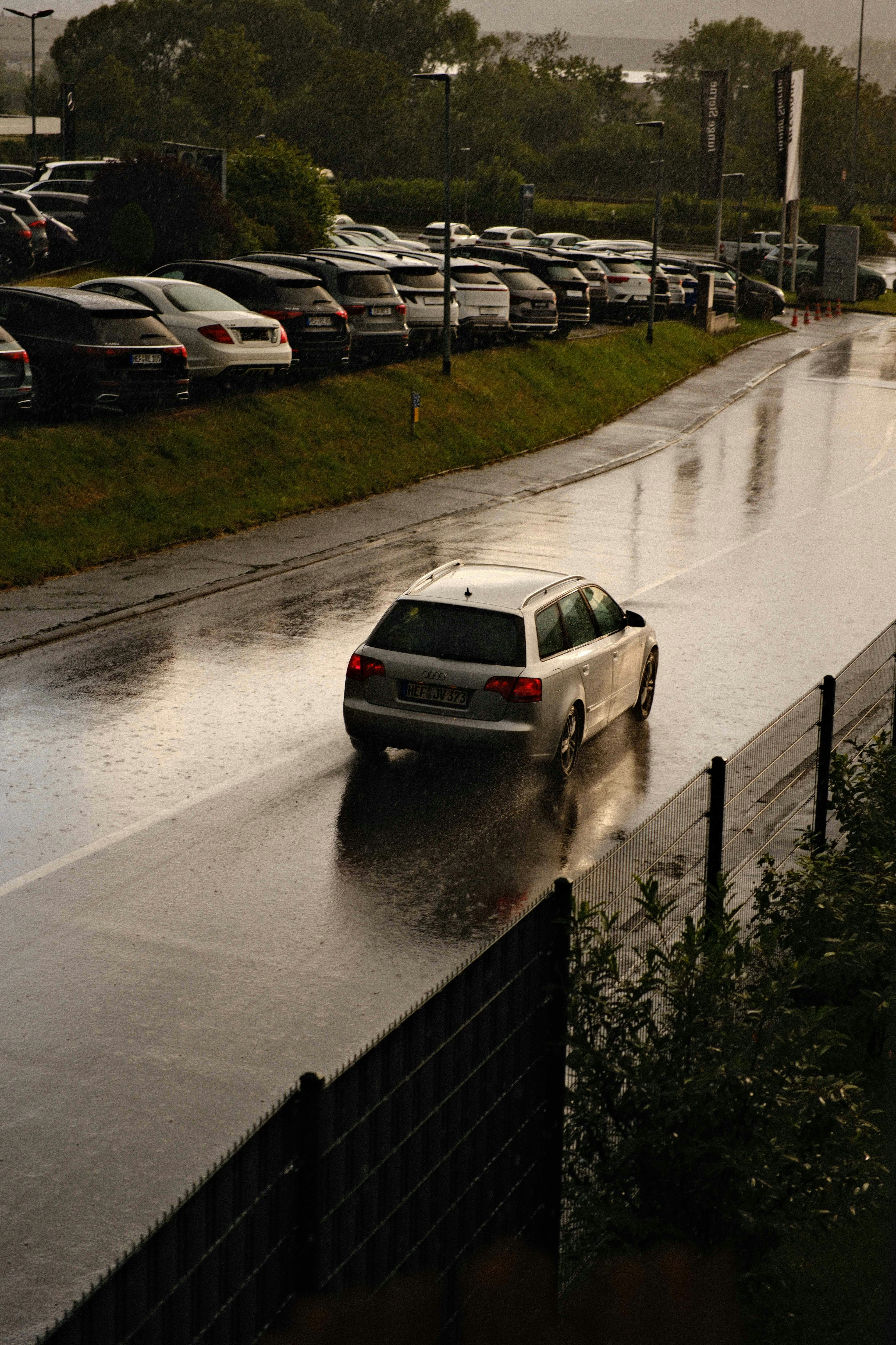 Raindrops on the Road: A Silver Wagon Cuts Through a Shiny Street