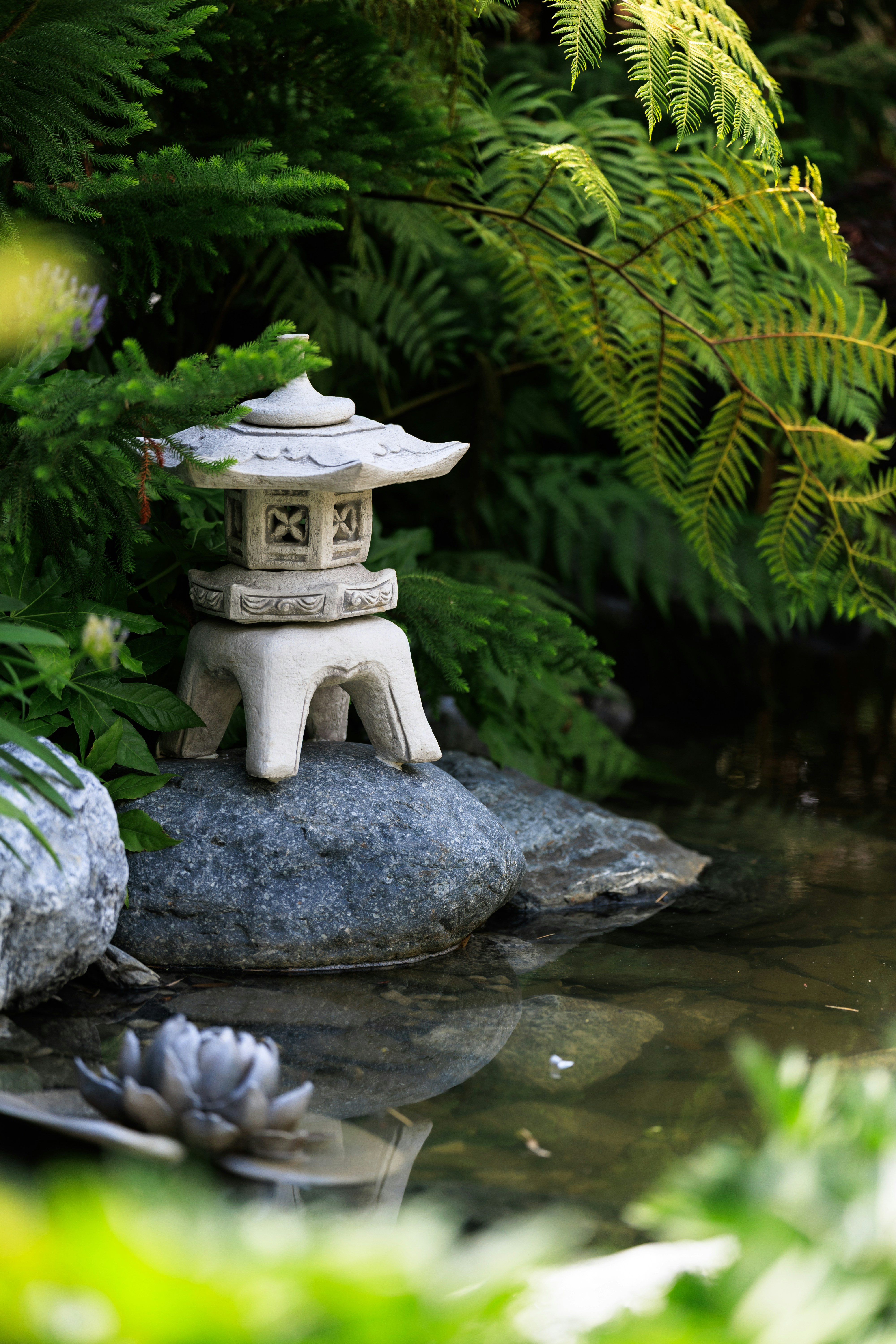 Stone Lantern among Greenery by Calm Pond