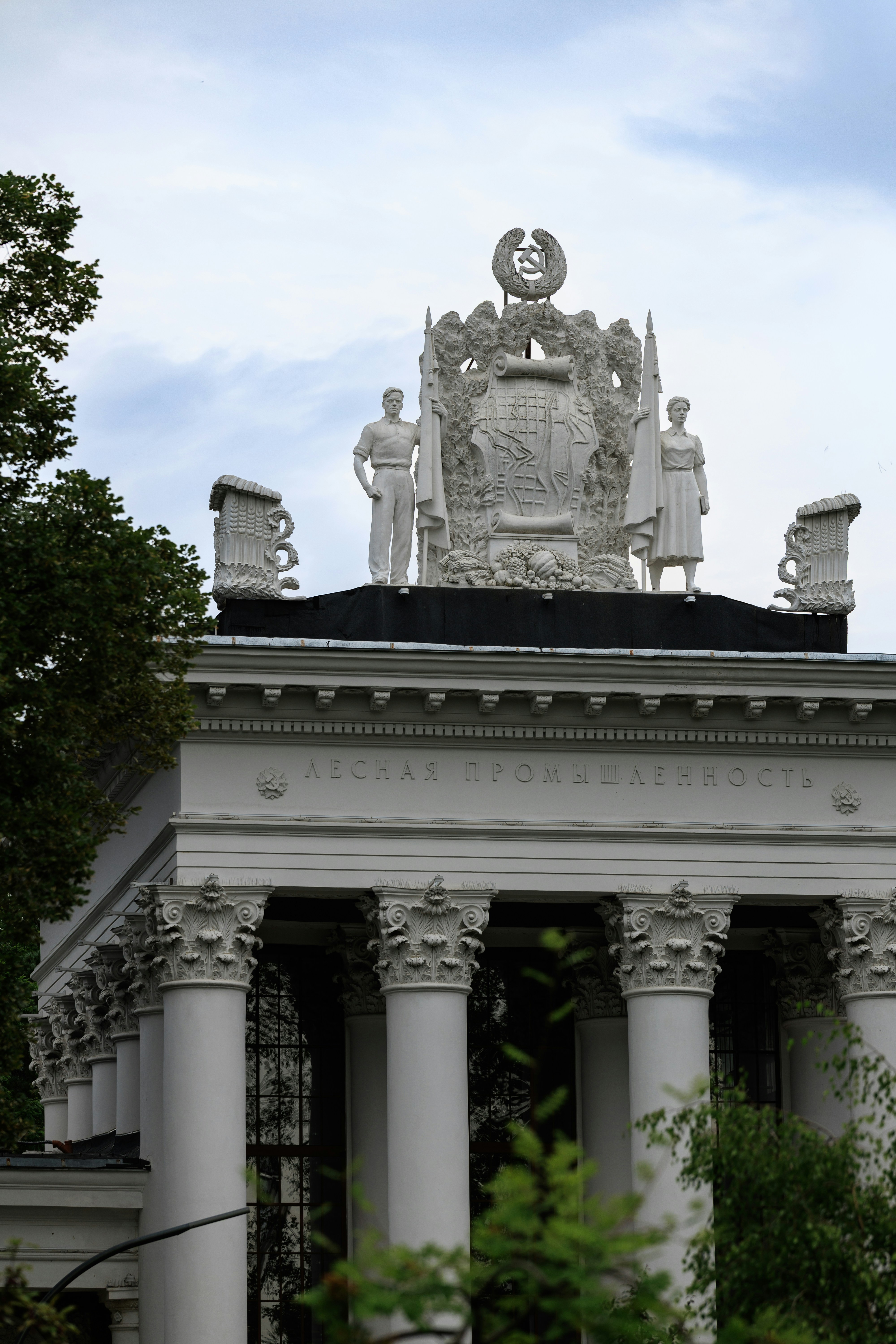 Statues atop a neoclassical pediment: guardians of an ornate administration facade