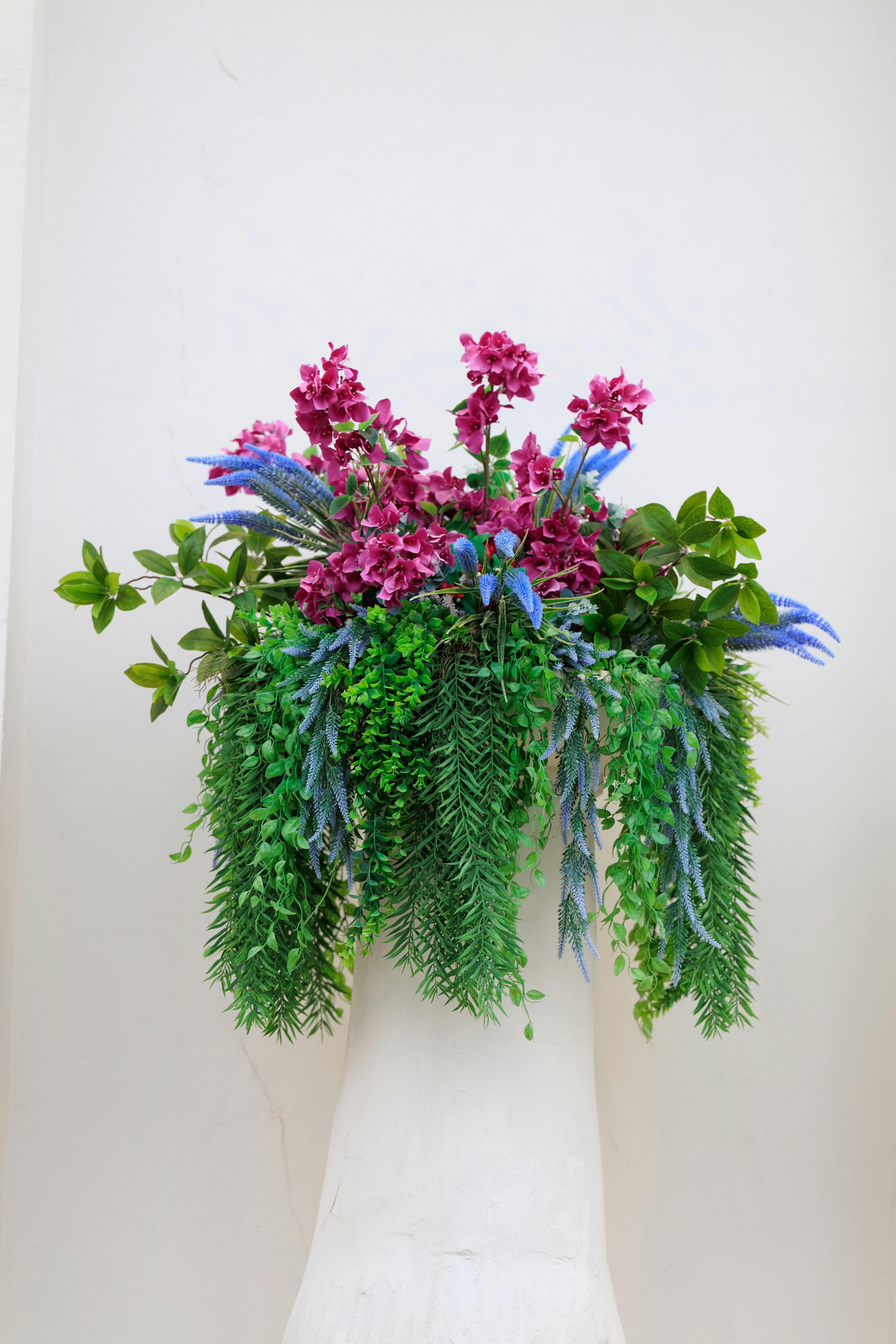 Blooming pedestal: a lush cascading arrangement above a white pedestal