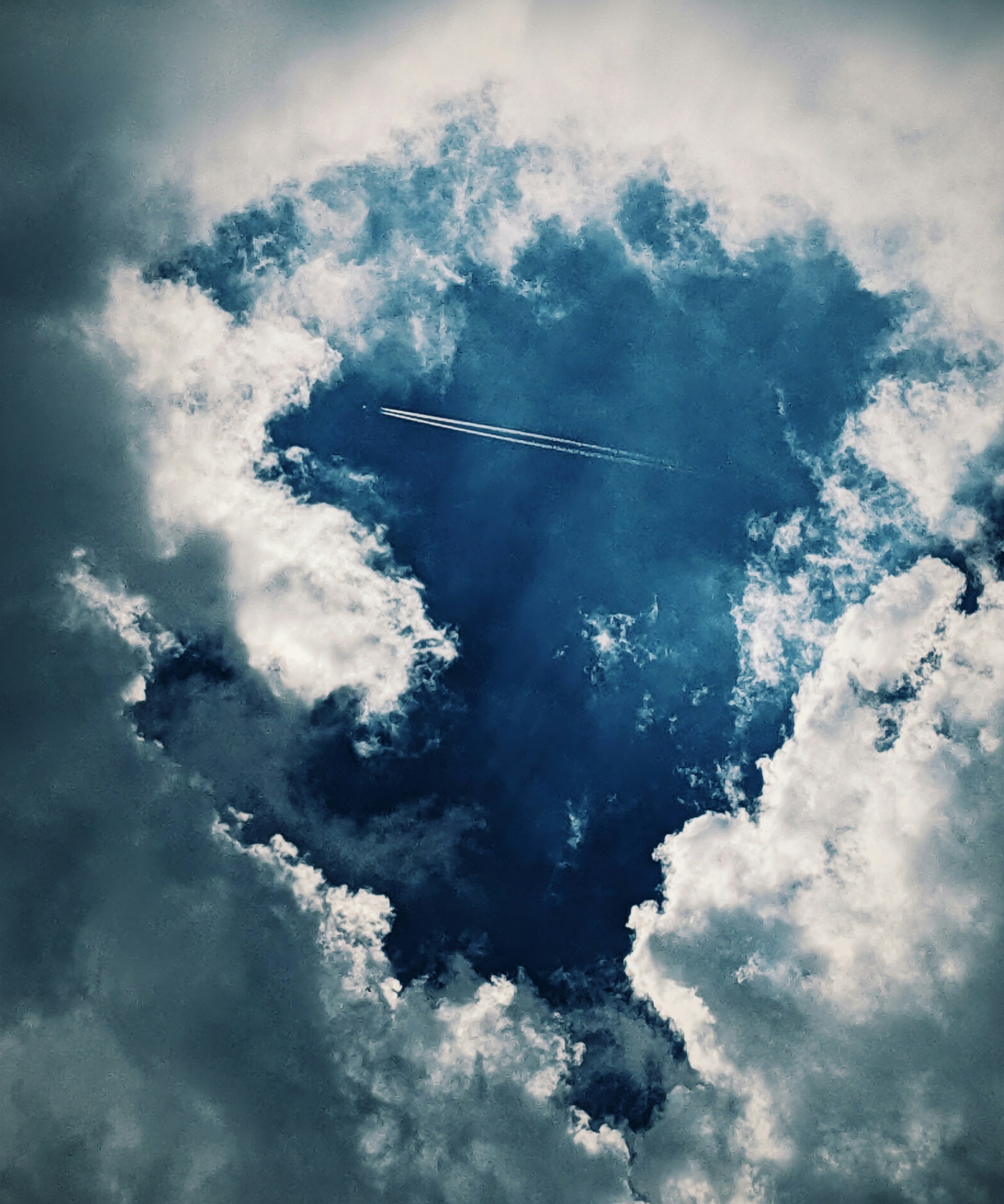 Jet Over Silence: A Contrail Cuts Through a Turbulent Blue Sky