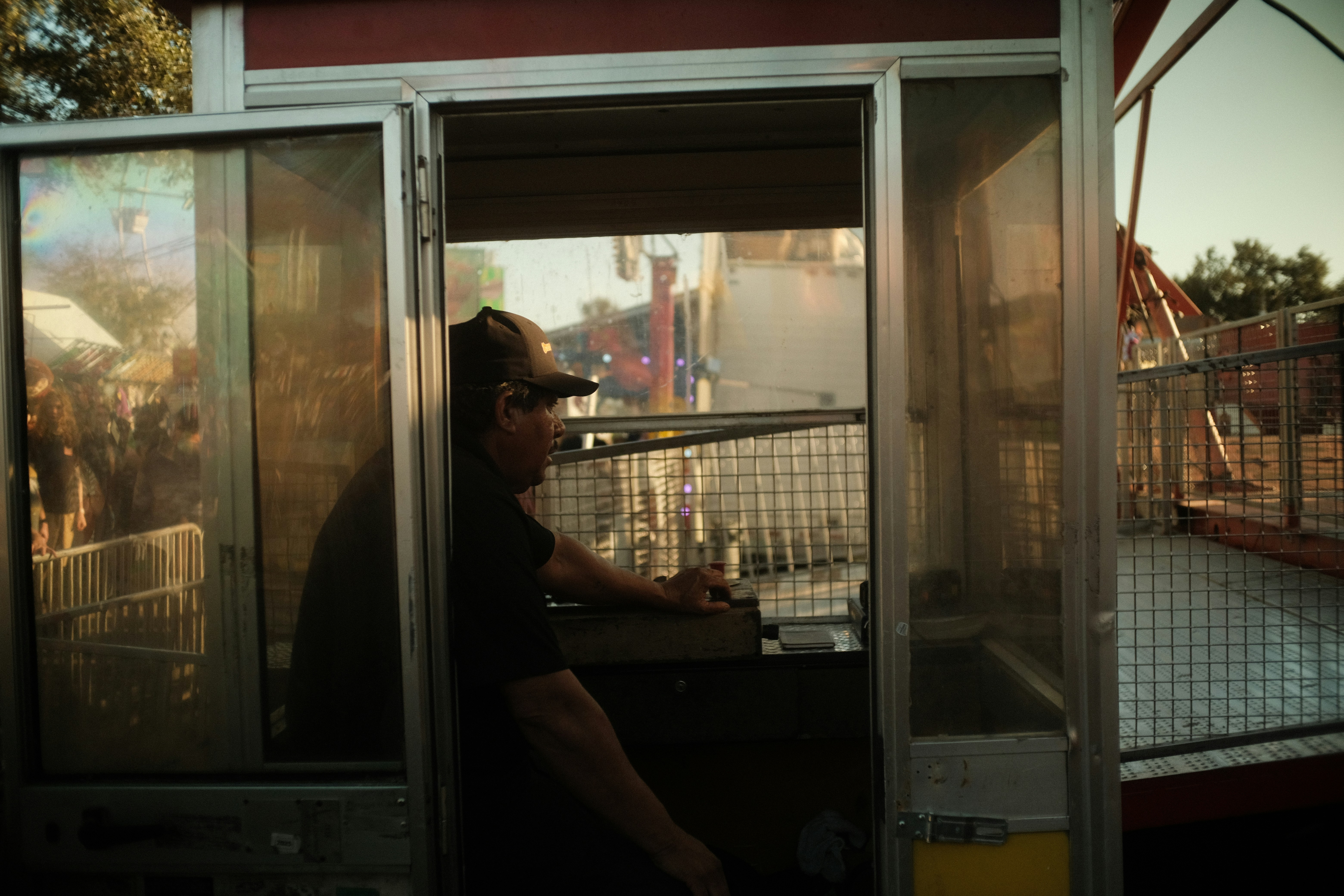 Behind the Glass: A Conductor in Shadows at a Farewell Carnival