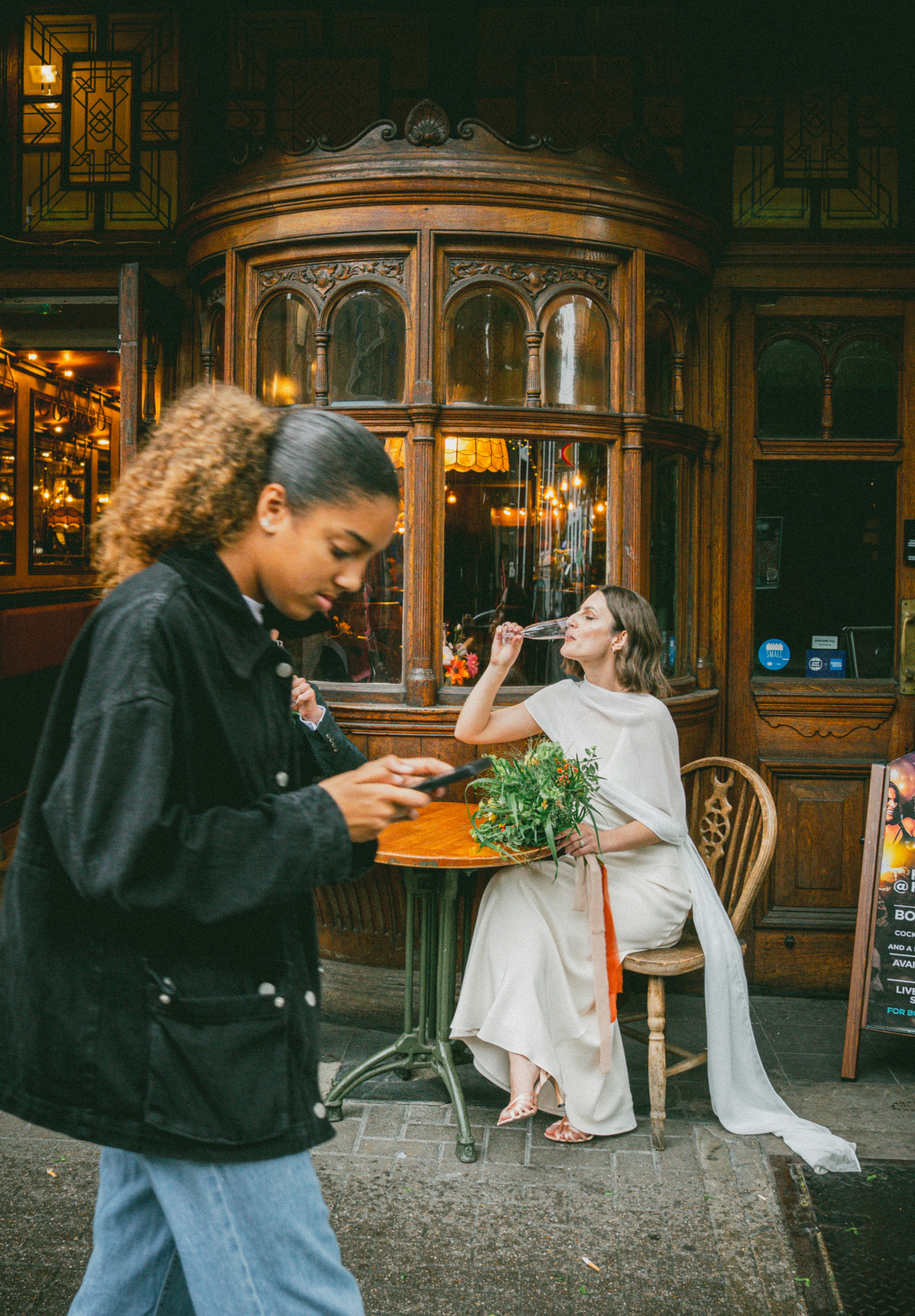 Two contrasting moments: a passerby and a seated companion at a vintage café