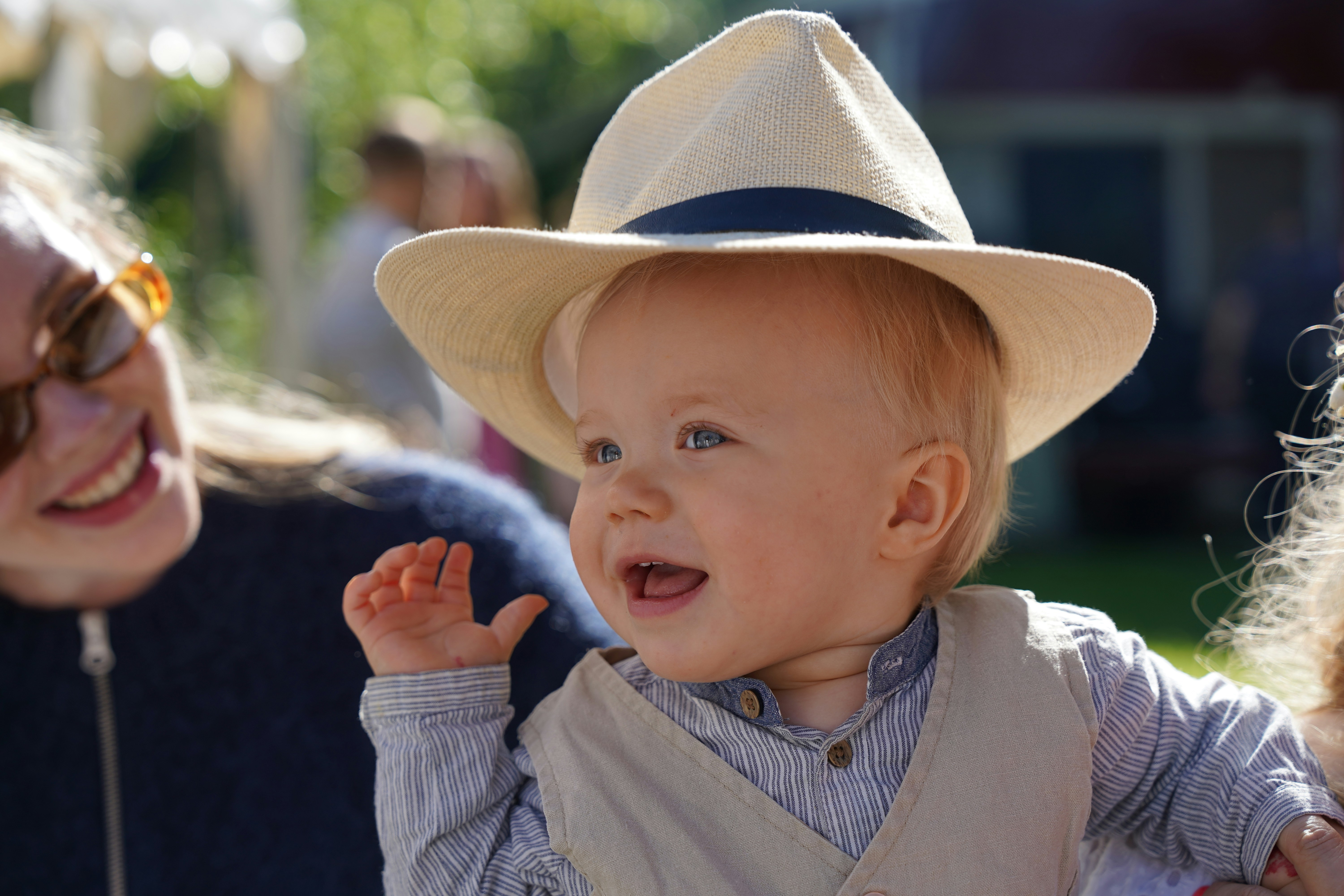 Sunlit Laughs: Baby in a Straw Fedora Reaches for the Day