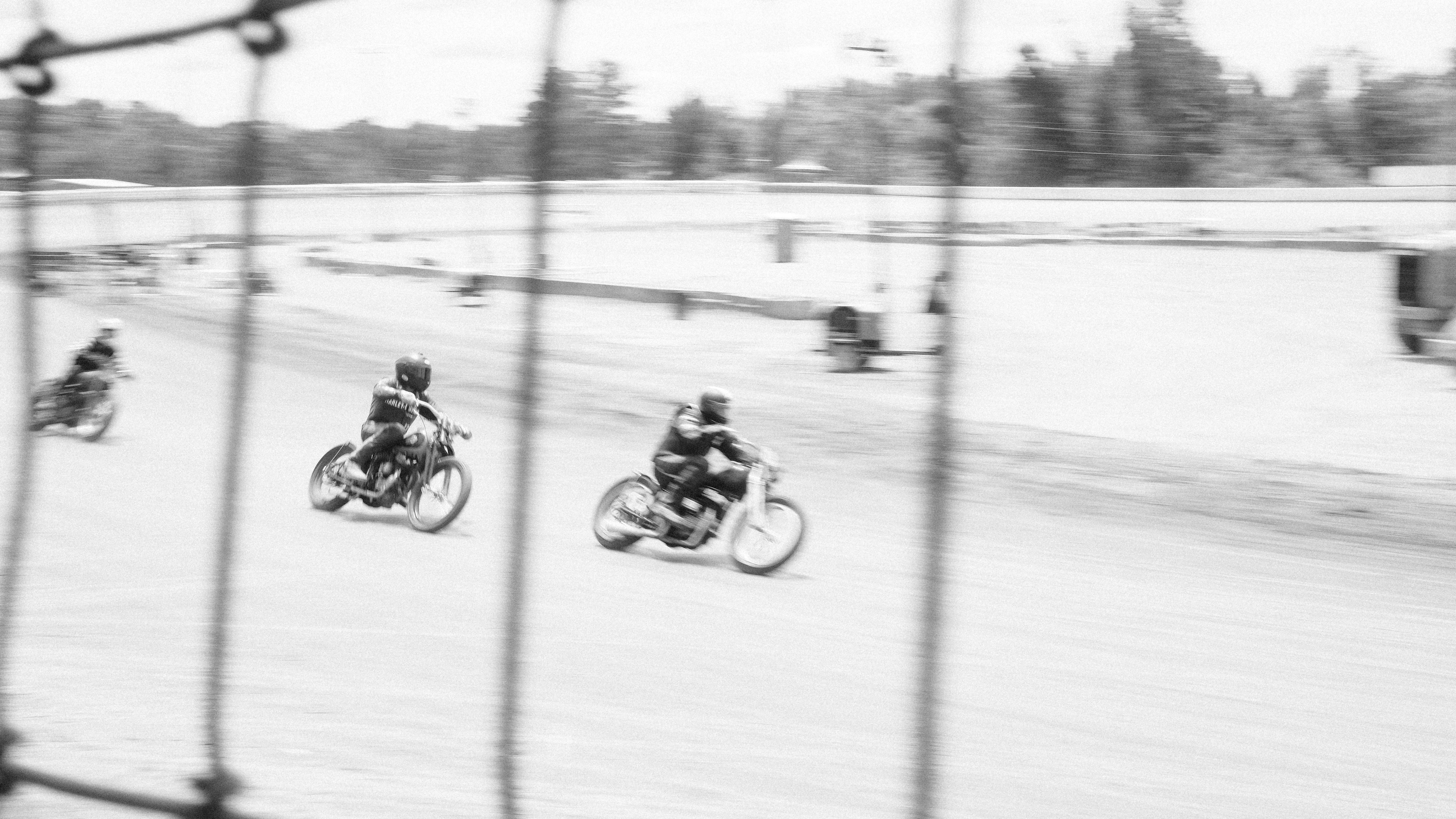 Mid-Race Blur: Vintage Motorbikes Sprint Across a Dusty Track