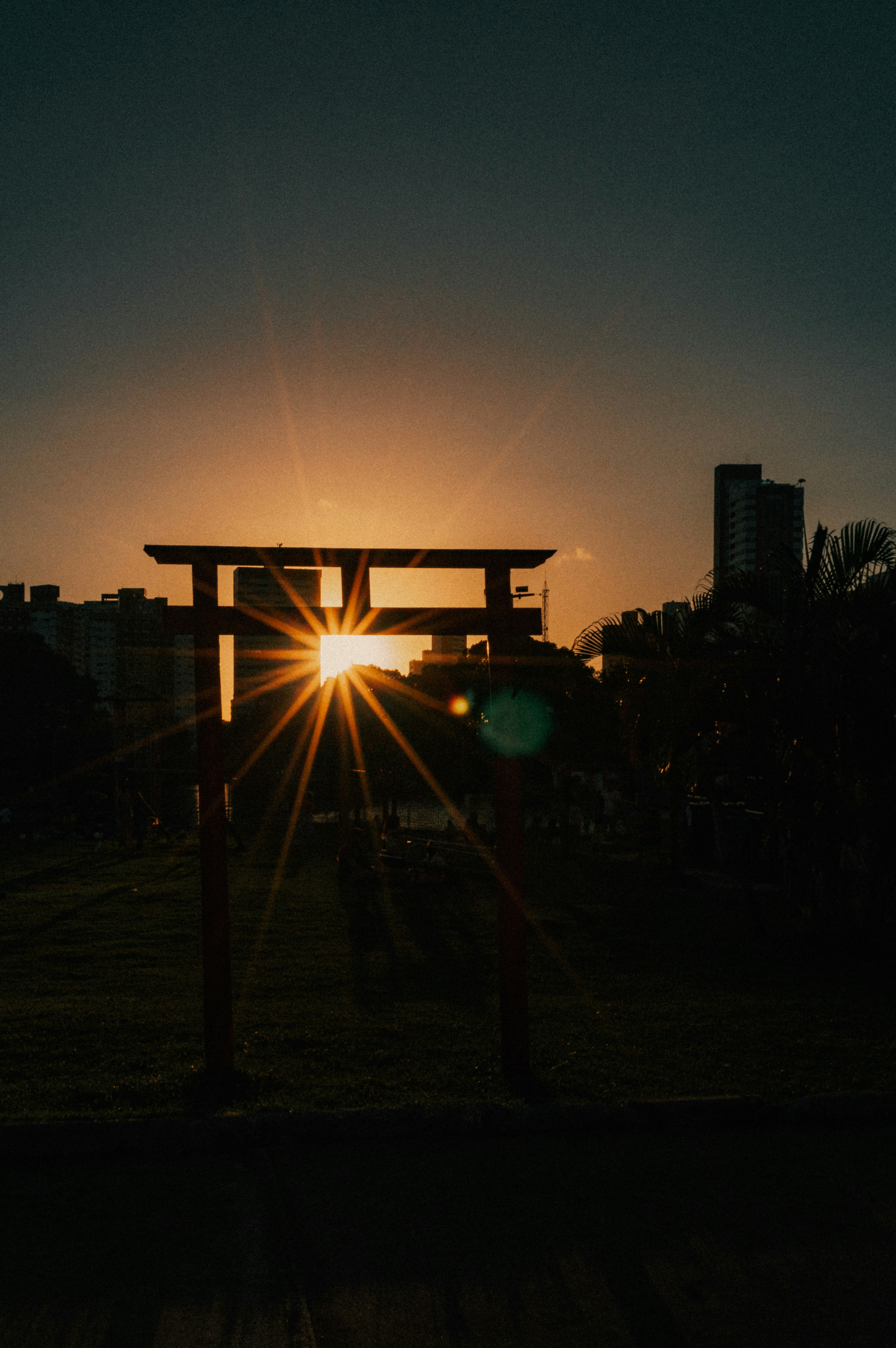 Sunburst Through a Torii: Urban Silhouette at Dusk