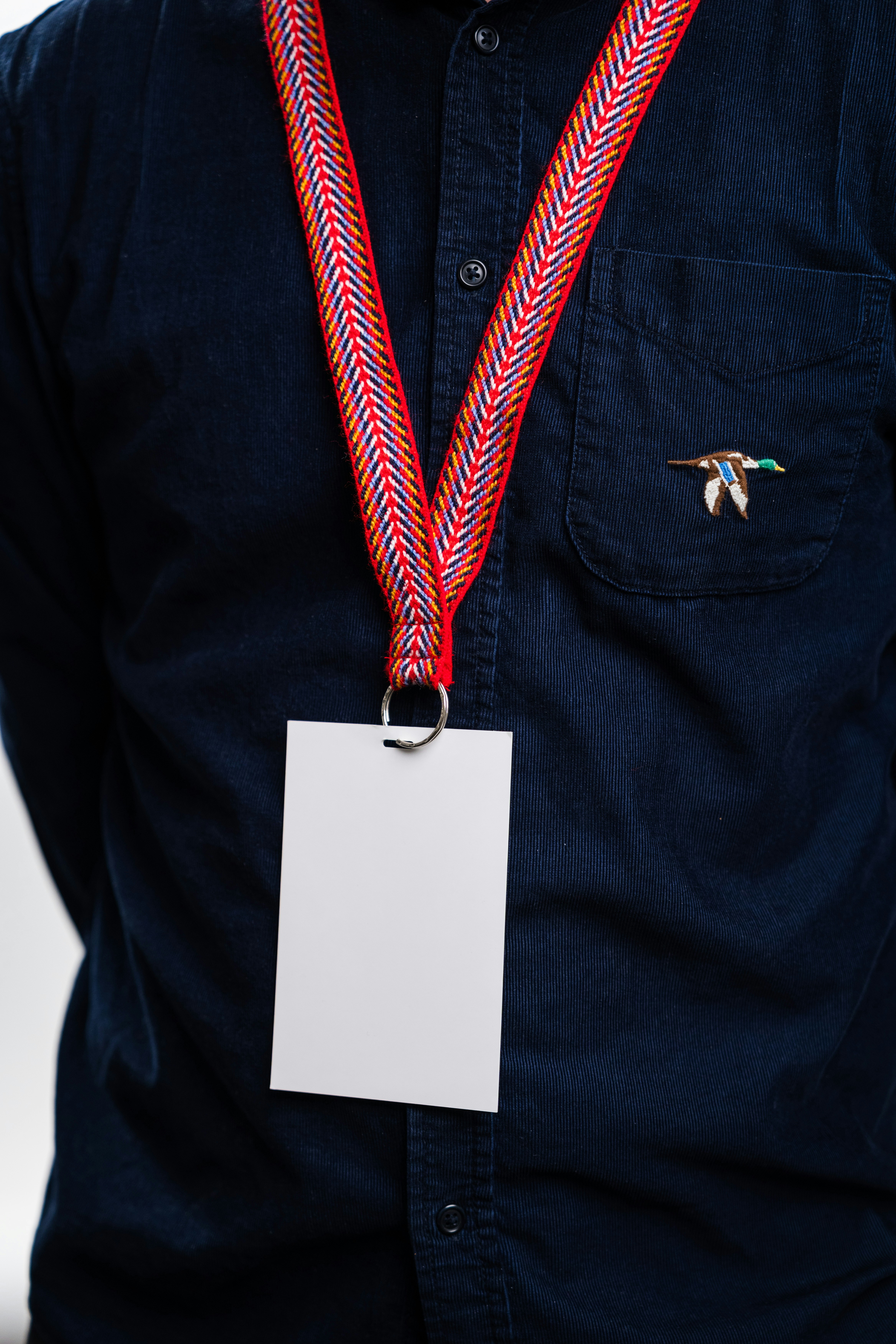 Lanyard with a blank badge resting on a dark chest pocket