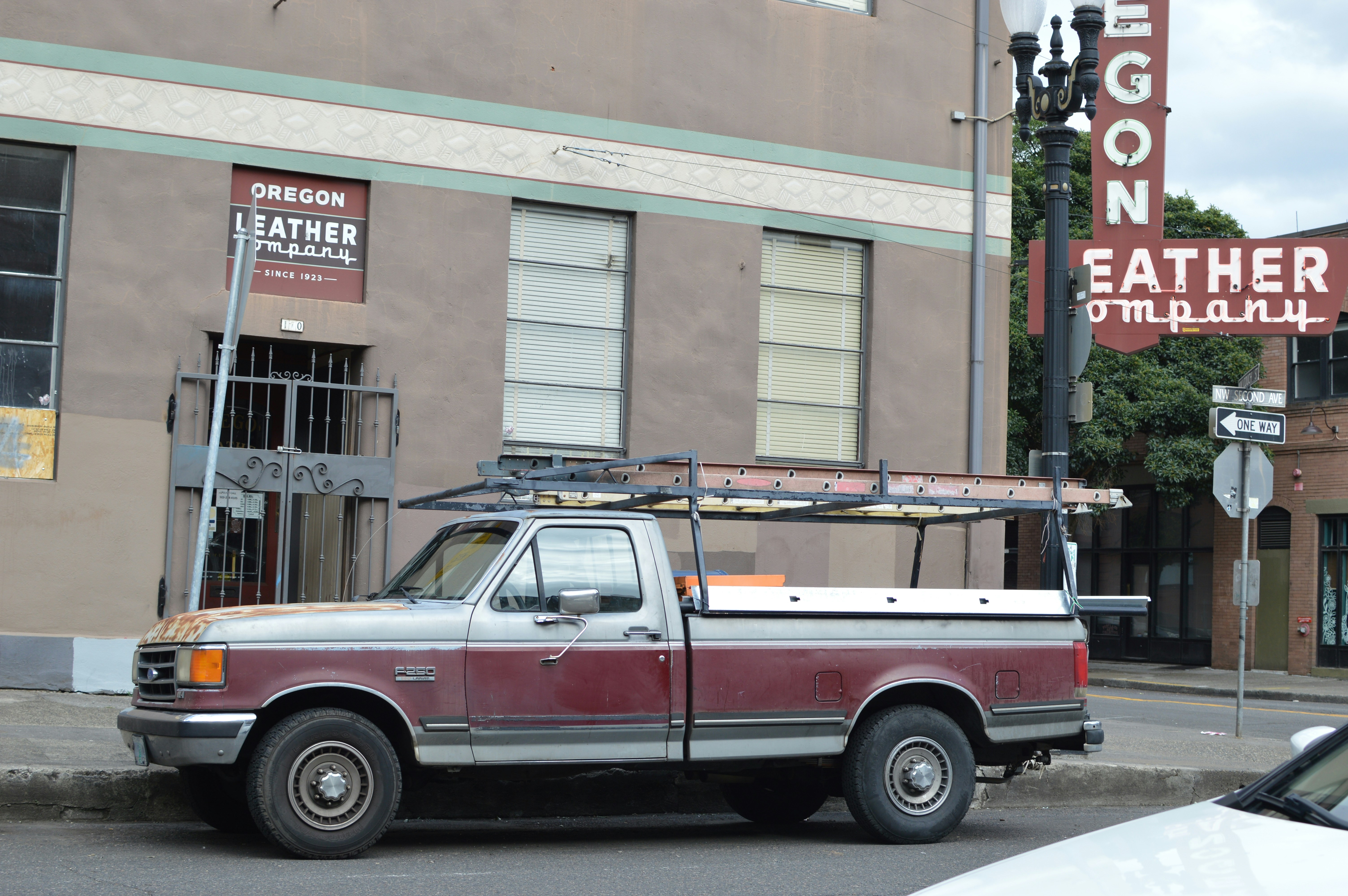 Red-and-silver utility pickup parked by a weathered storefront