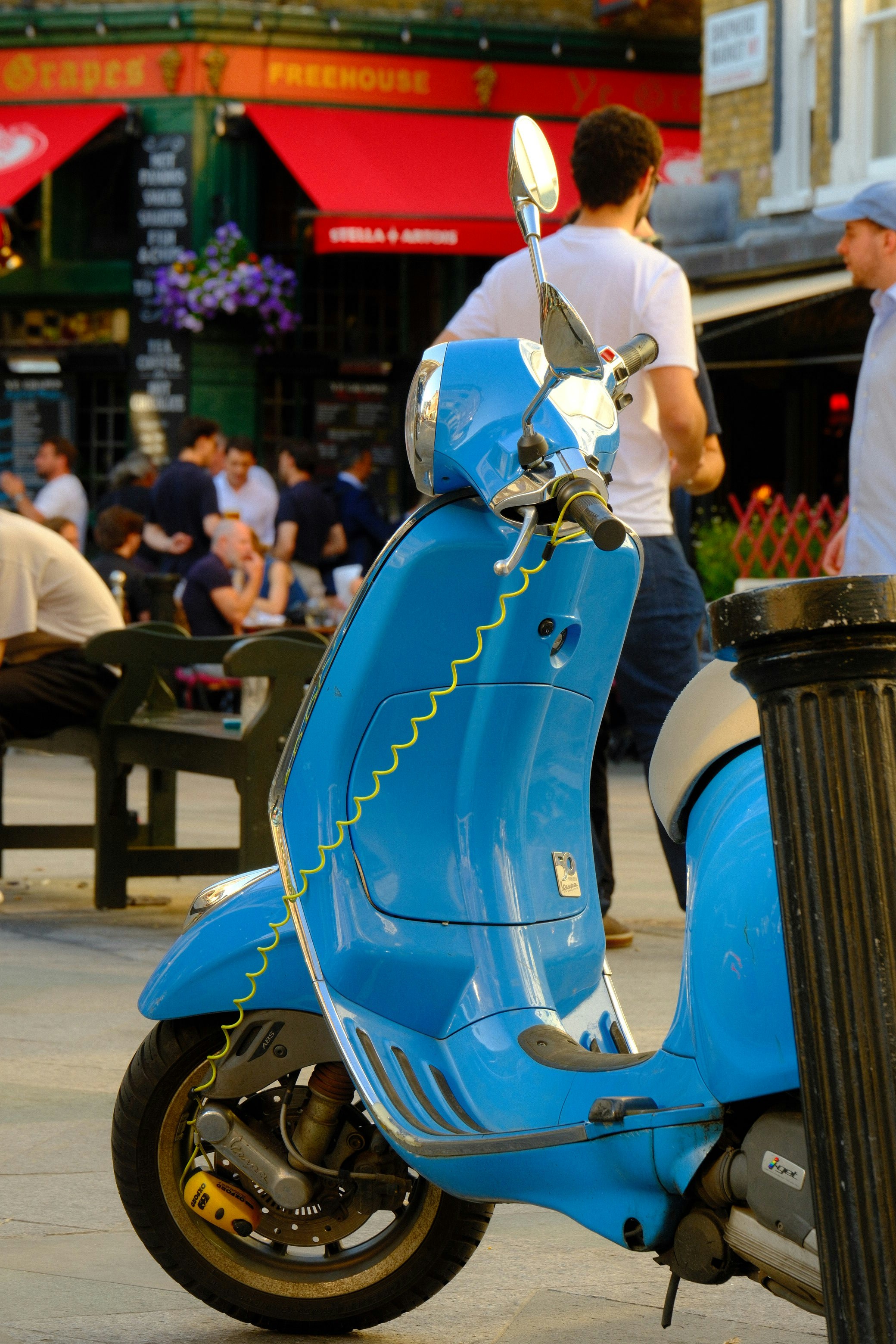 Blue Vespa on a Bustling Street