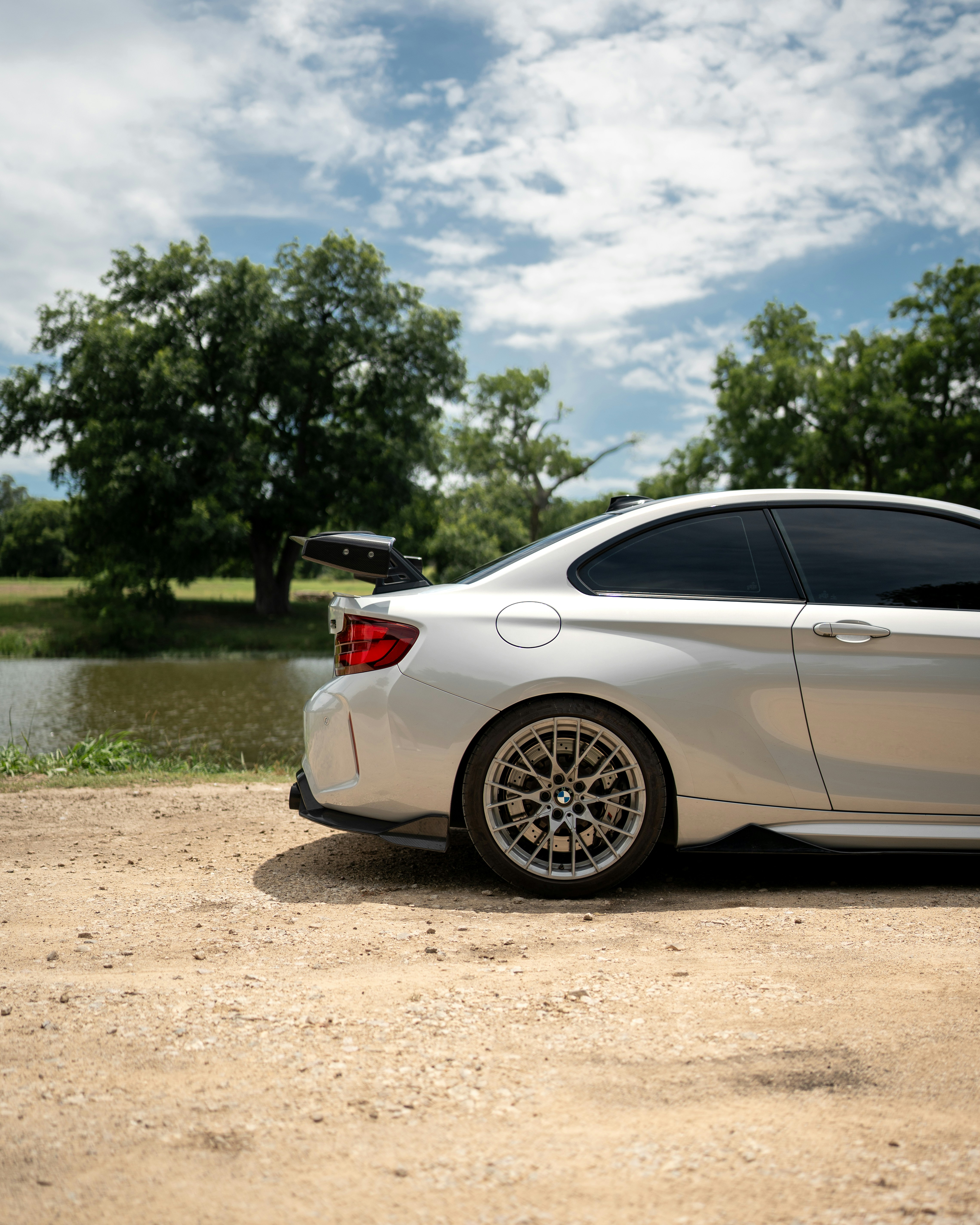 Rear-ward Airflow and Silver Curves: A BMW-Style Sedan by the Pond