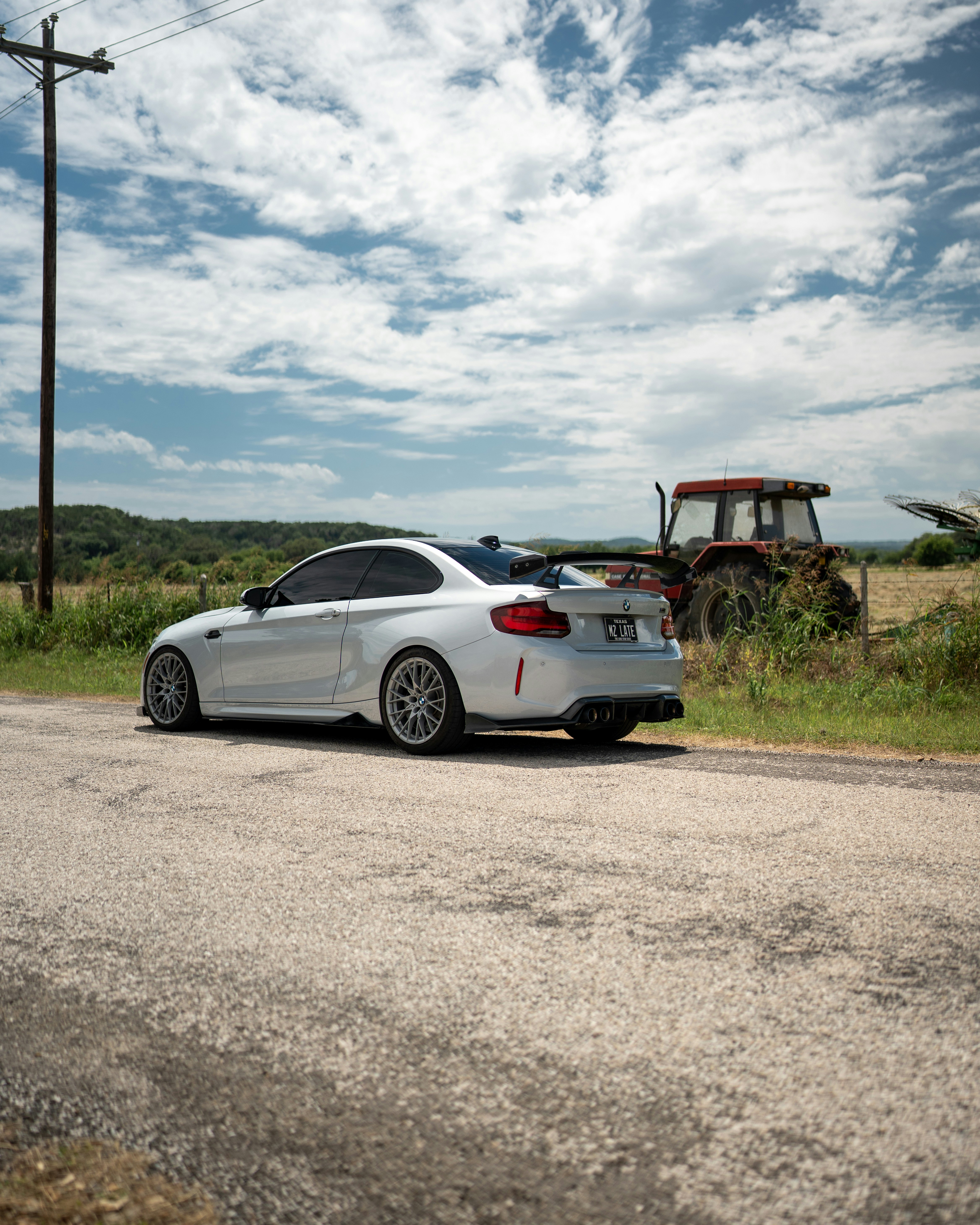 Silver BMW Bumper-to-Field: A Quiet Stance by the Farm