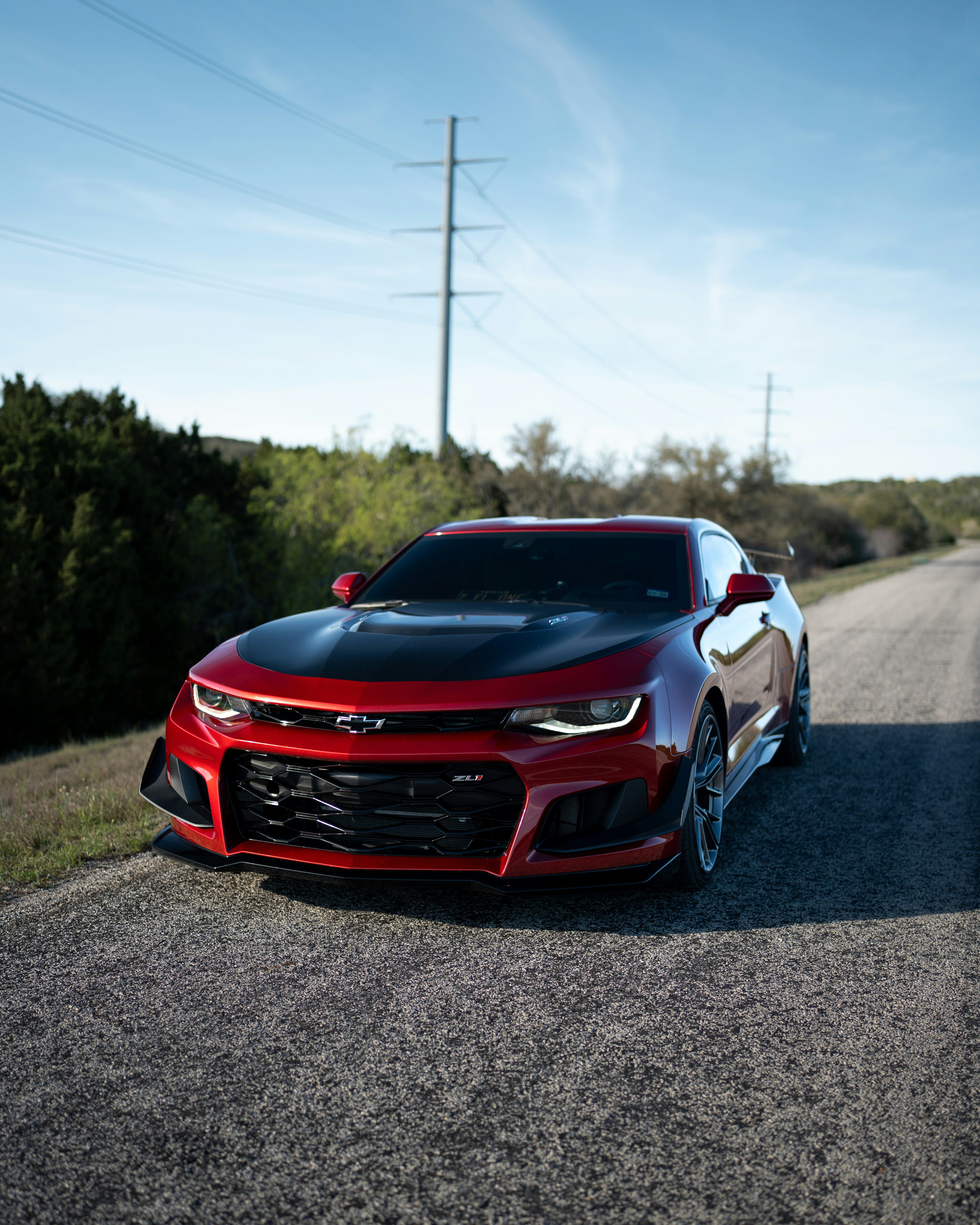 A red chevrolet camaro parked on a road.