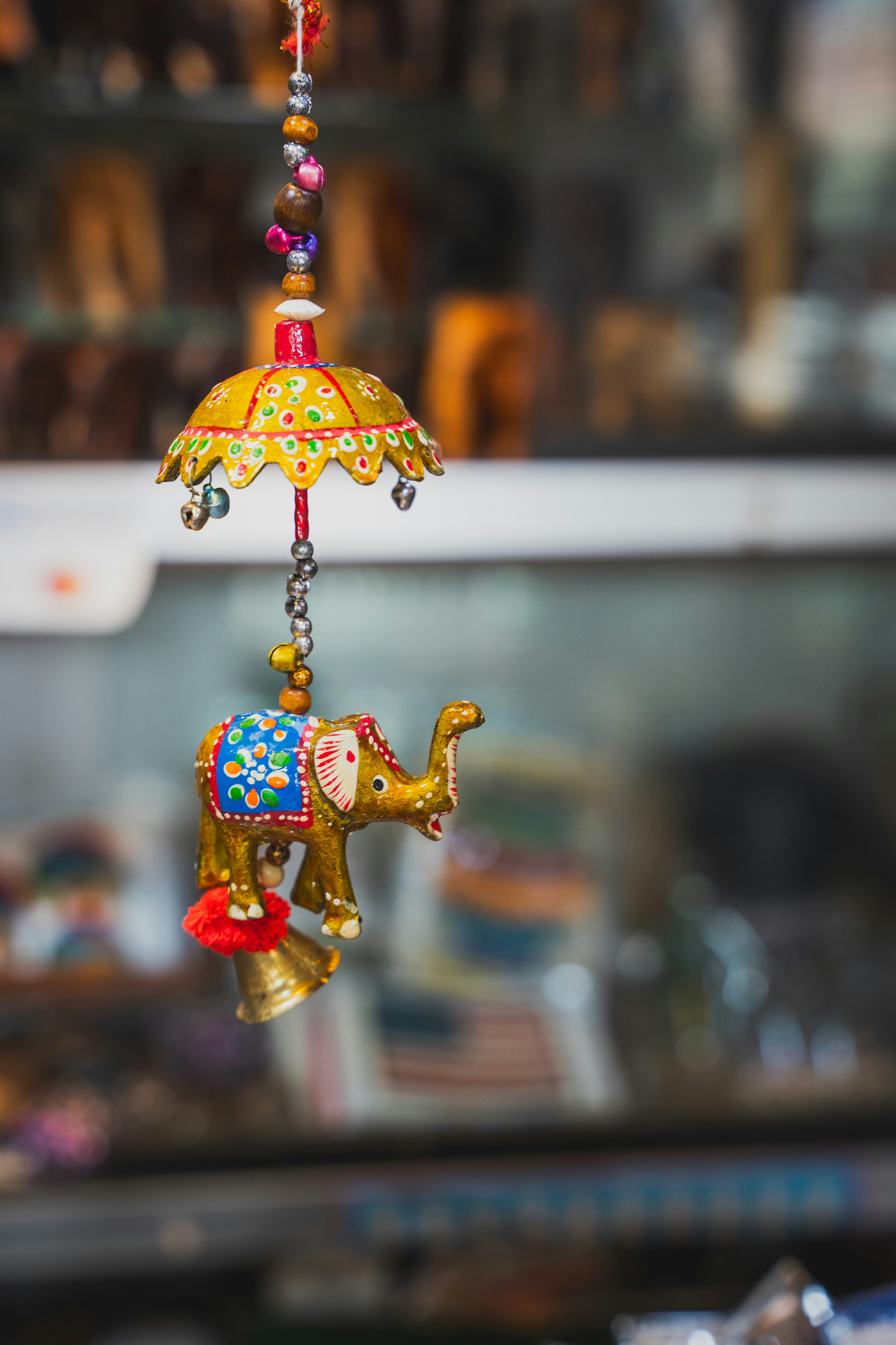 Hanging Ornament: A Colorful Elephant Pendant against a Busy Backdrop