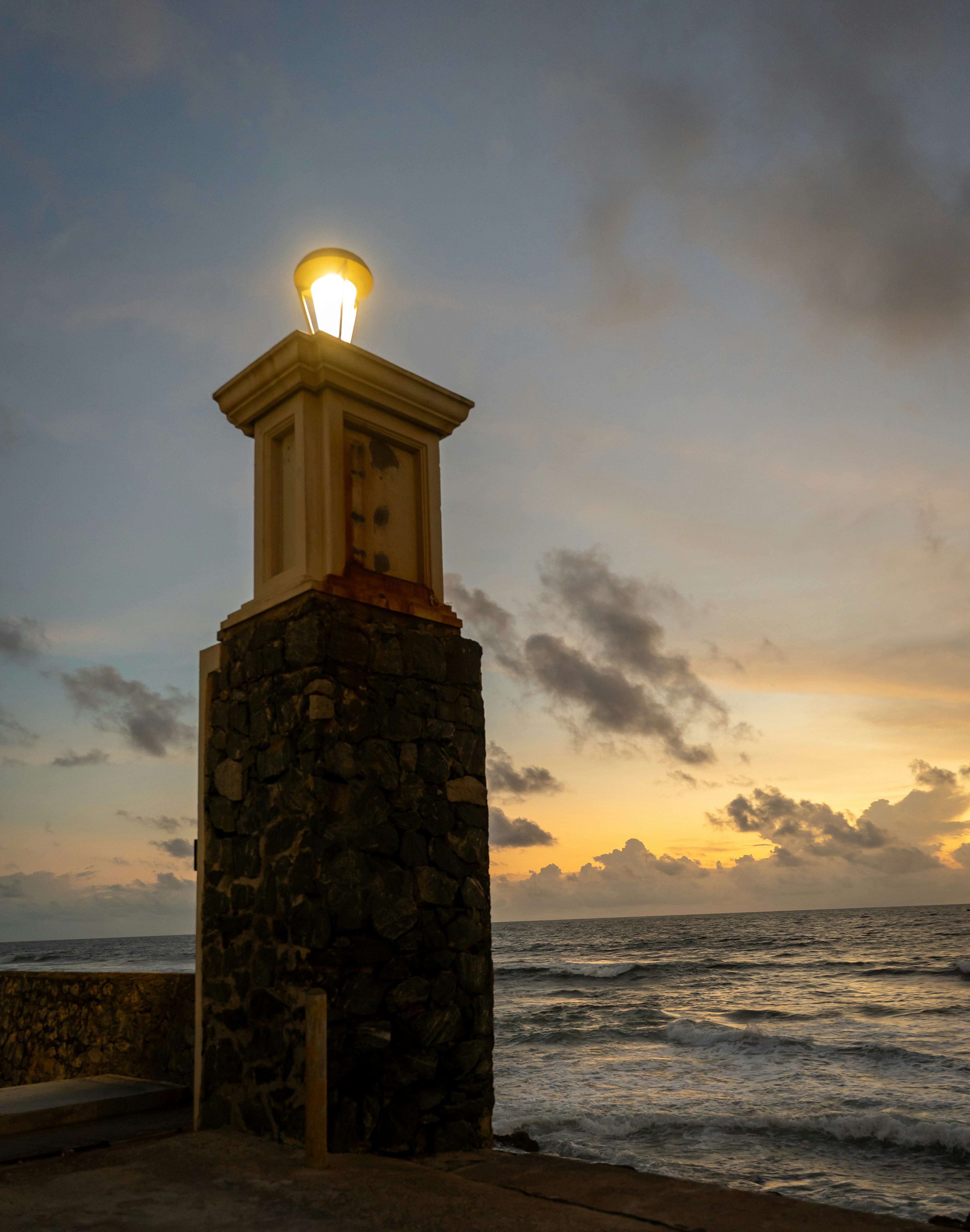 Lighthouse on the Edge: Warm Lamp on a Sea-Quiet Dusk