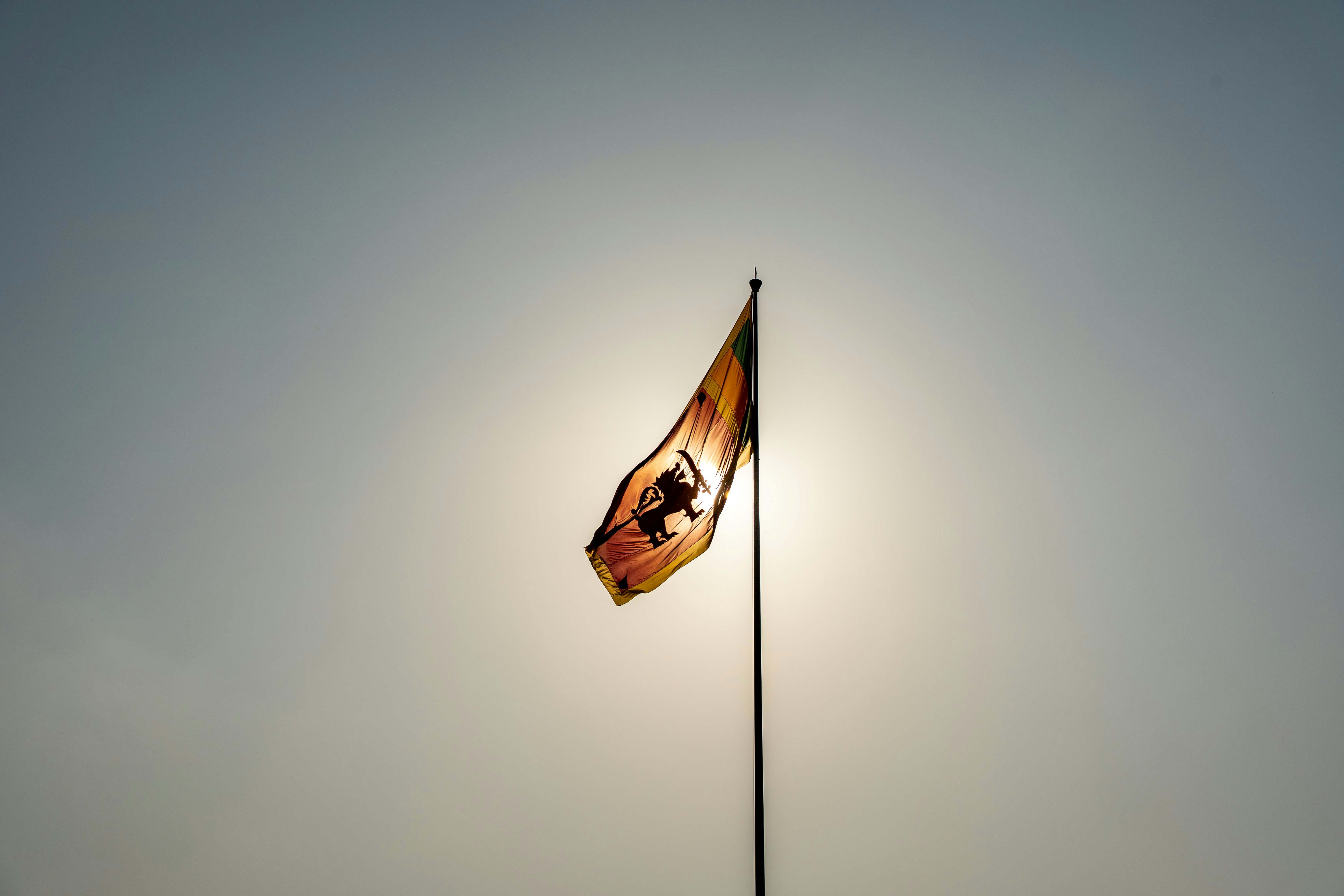 Flag Against the Sun: A Silhouette of Pride and Pole