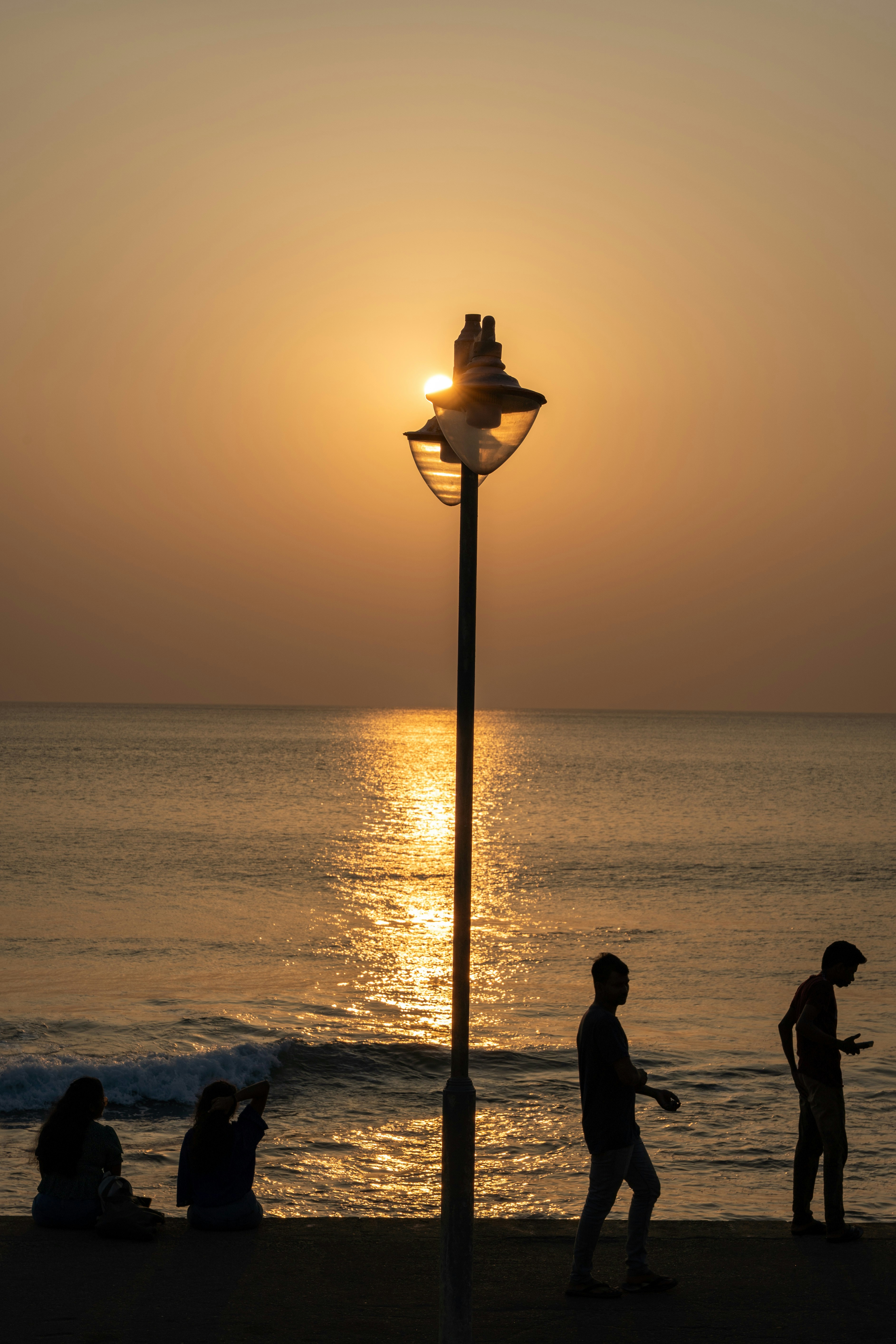 Sunlit silhouette by the pier lamp at golden hour