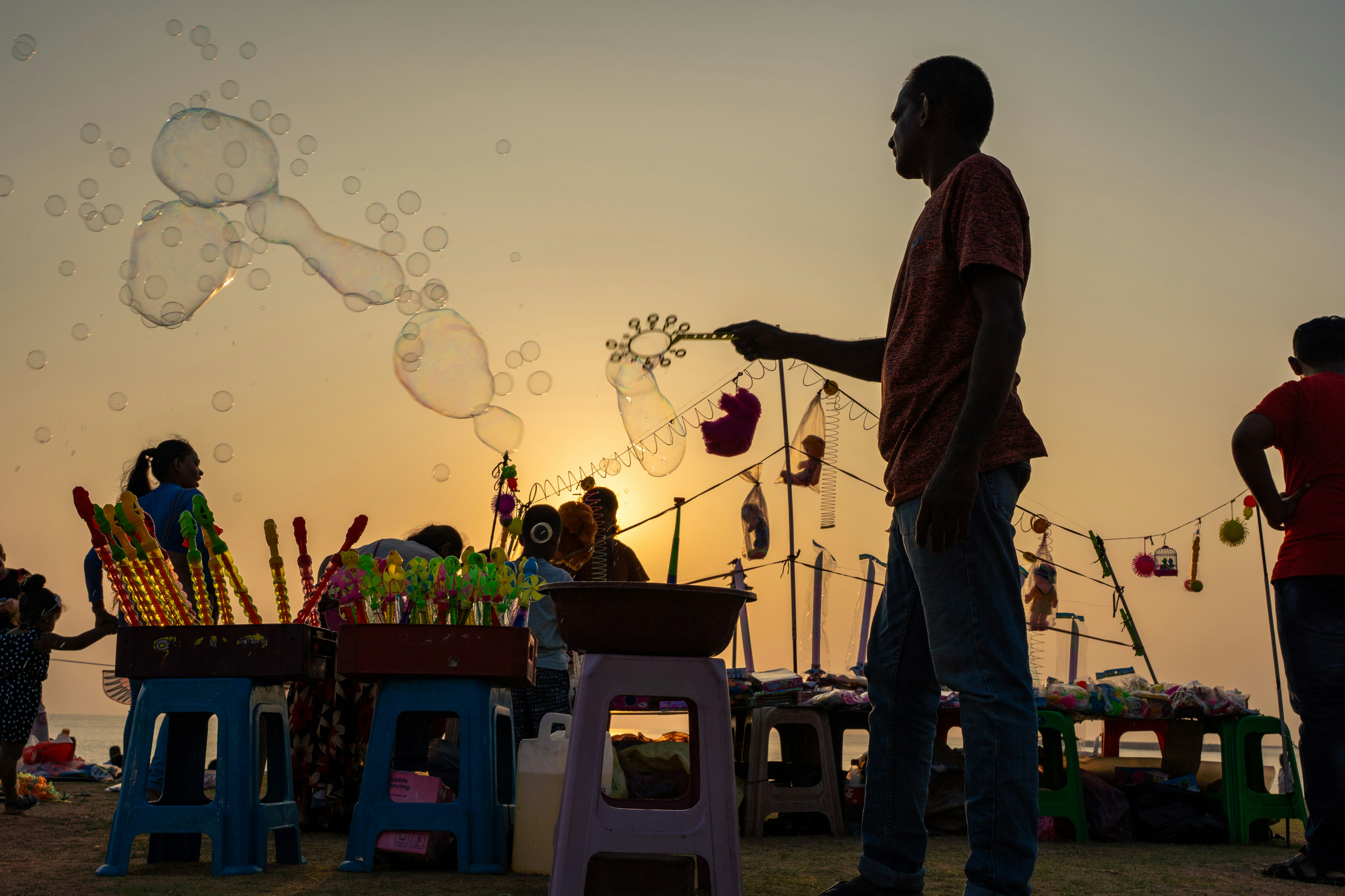 Silhouette Vendor at Dusk: Balloons, Bubbles and Bazaar Lights