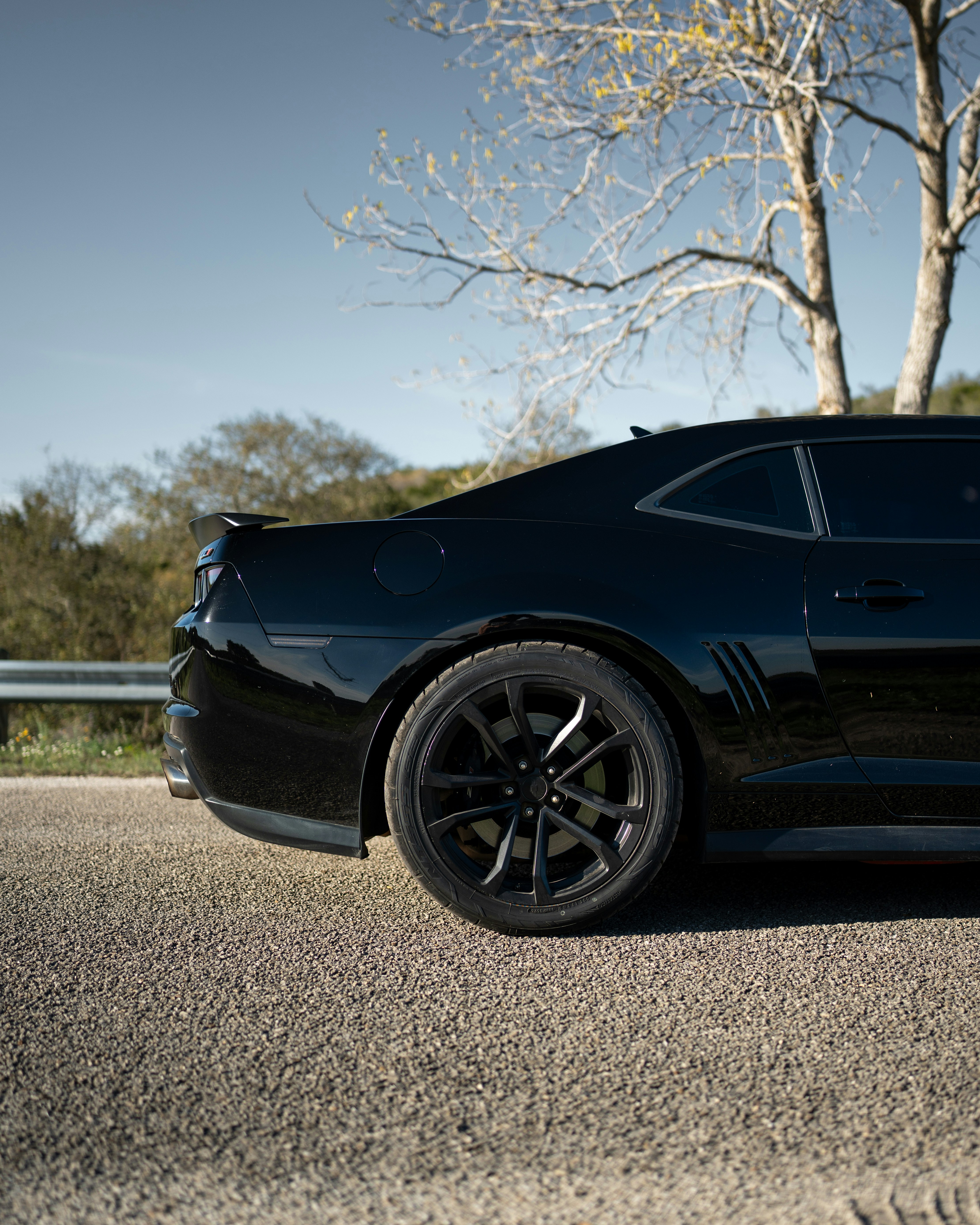 Midnight Velocity: A Sleek Black Coupe parked on a sunlit highway