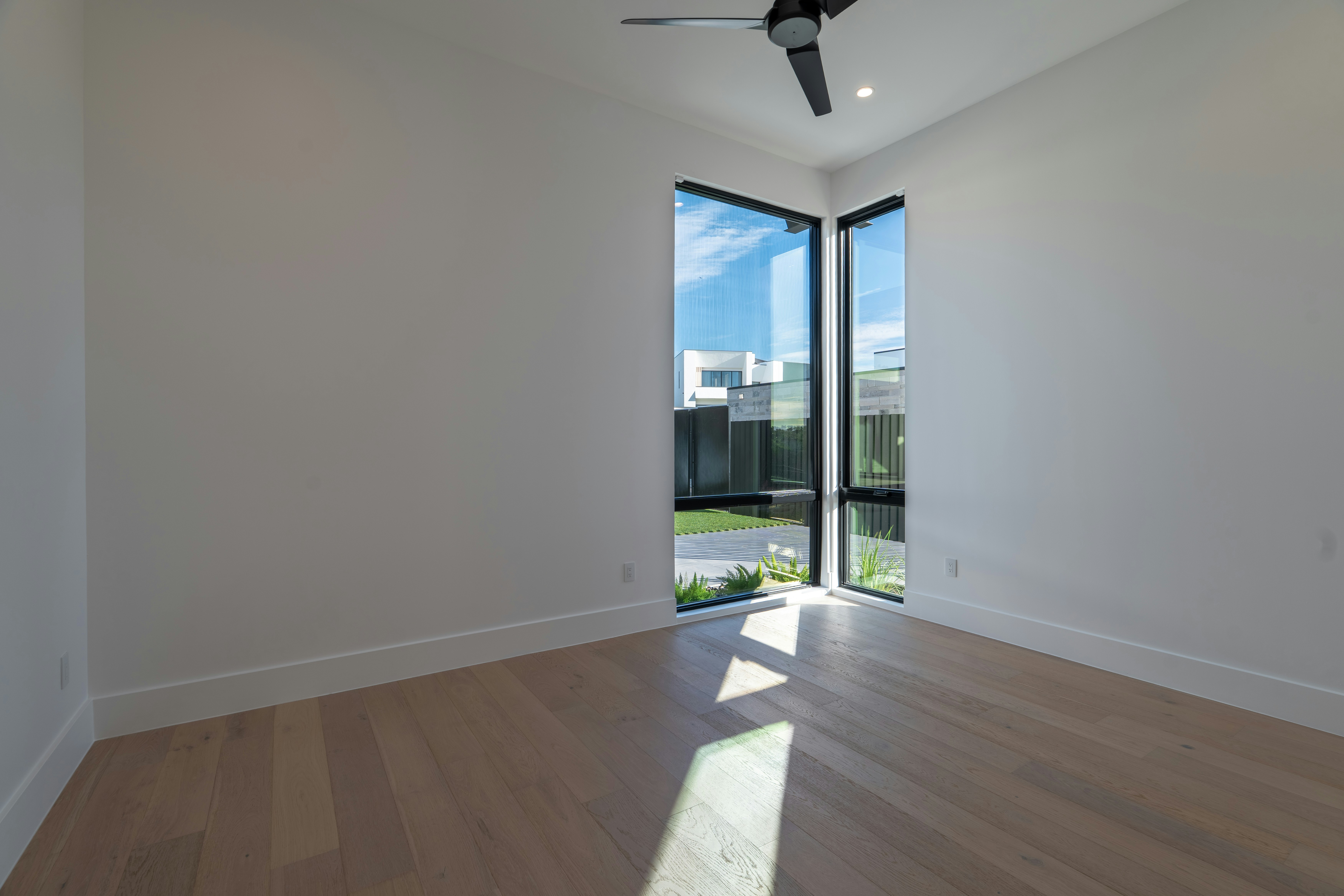 Sunlit Corner: Minimalist Room Framed by Quiet Outdoor View