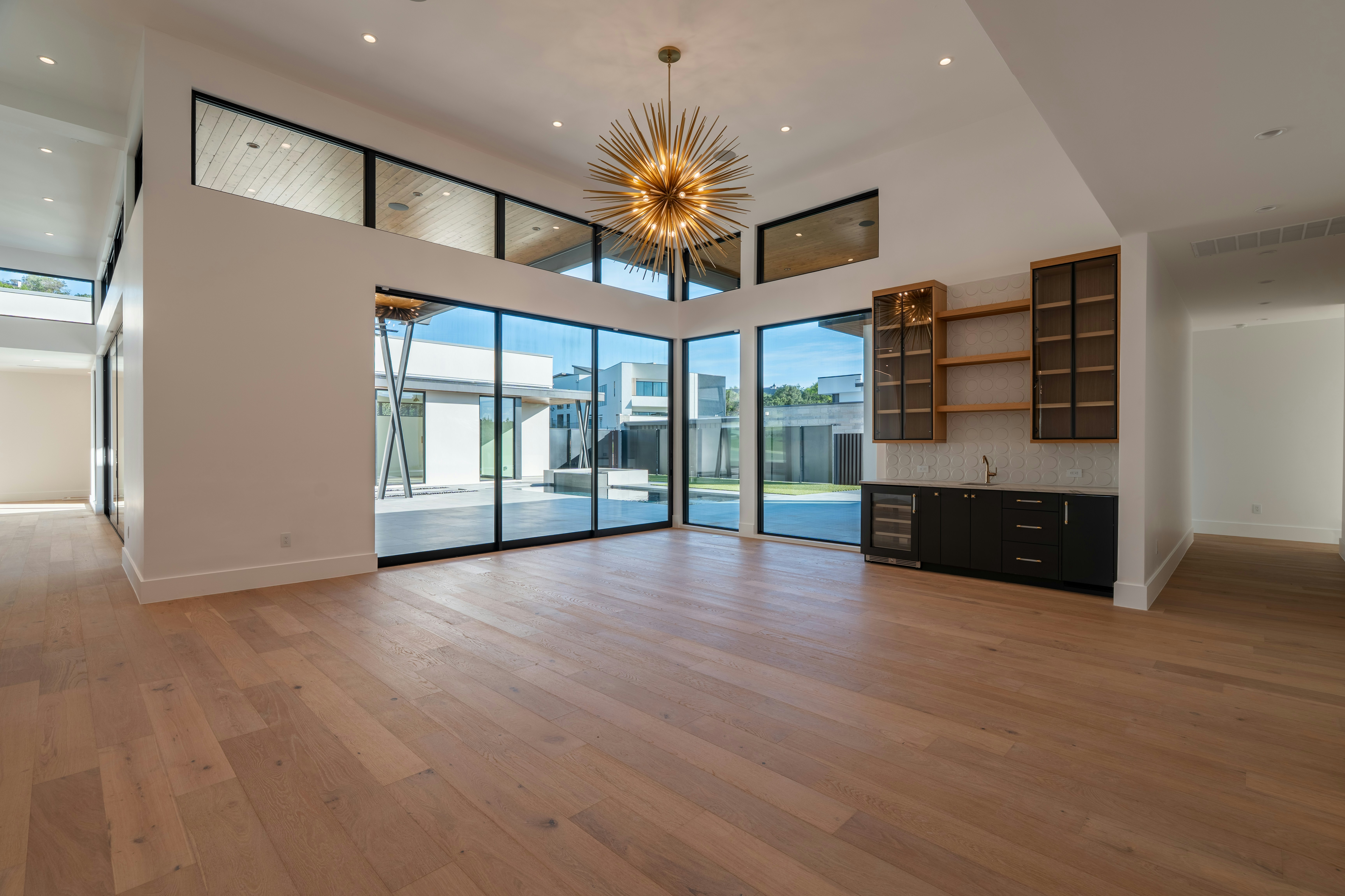 Sunlit Minimalist Living Room with Glass Walls and Built-In Kitchen Nook