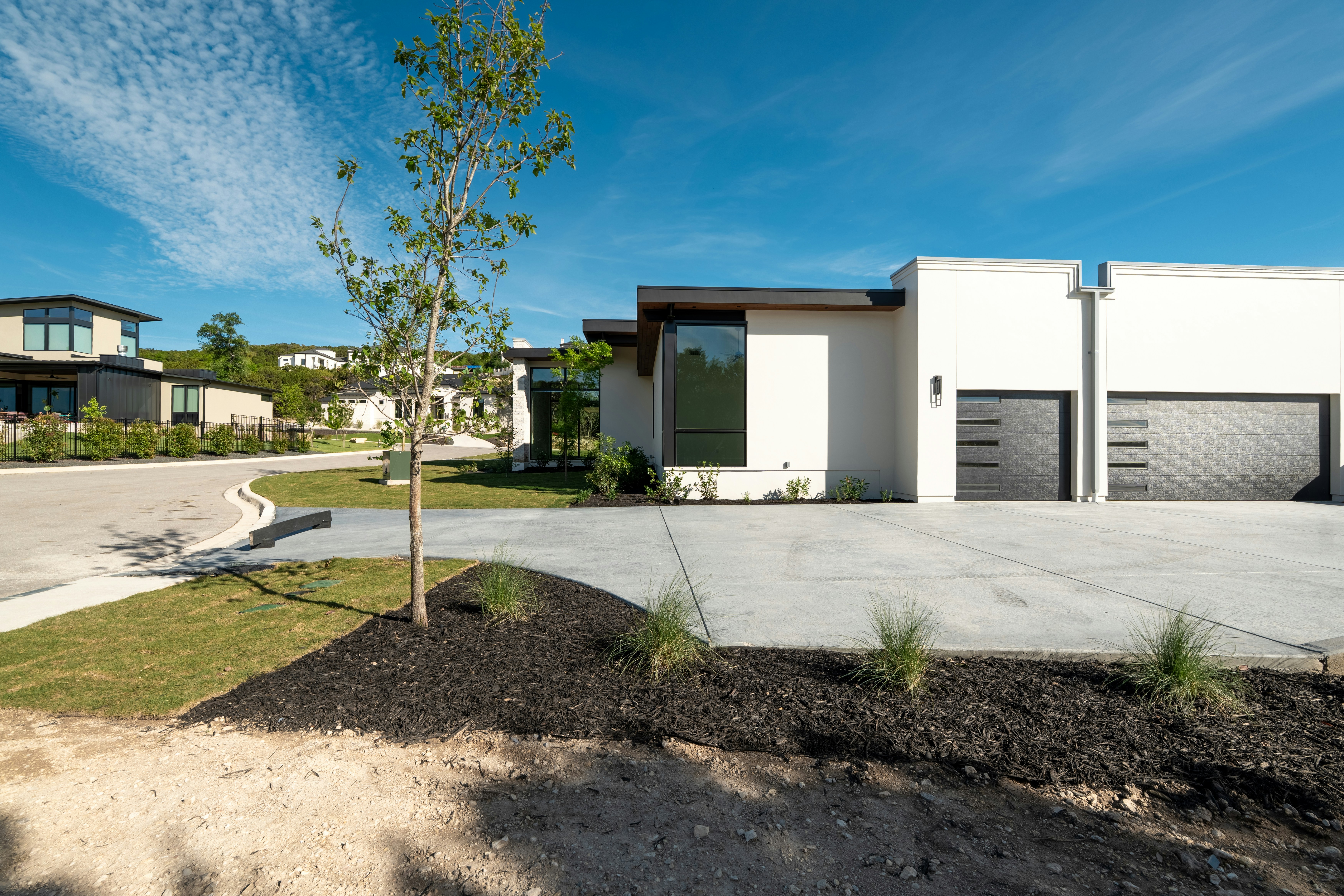 Sunlit Modern Suburb: Geometric Homes Against a Clear Sky